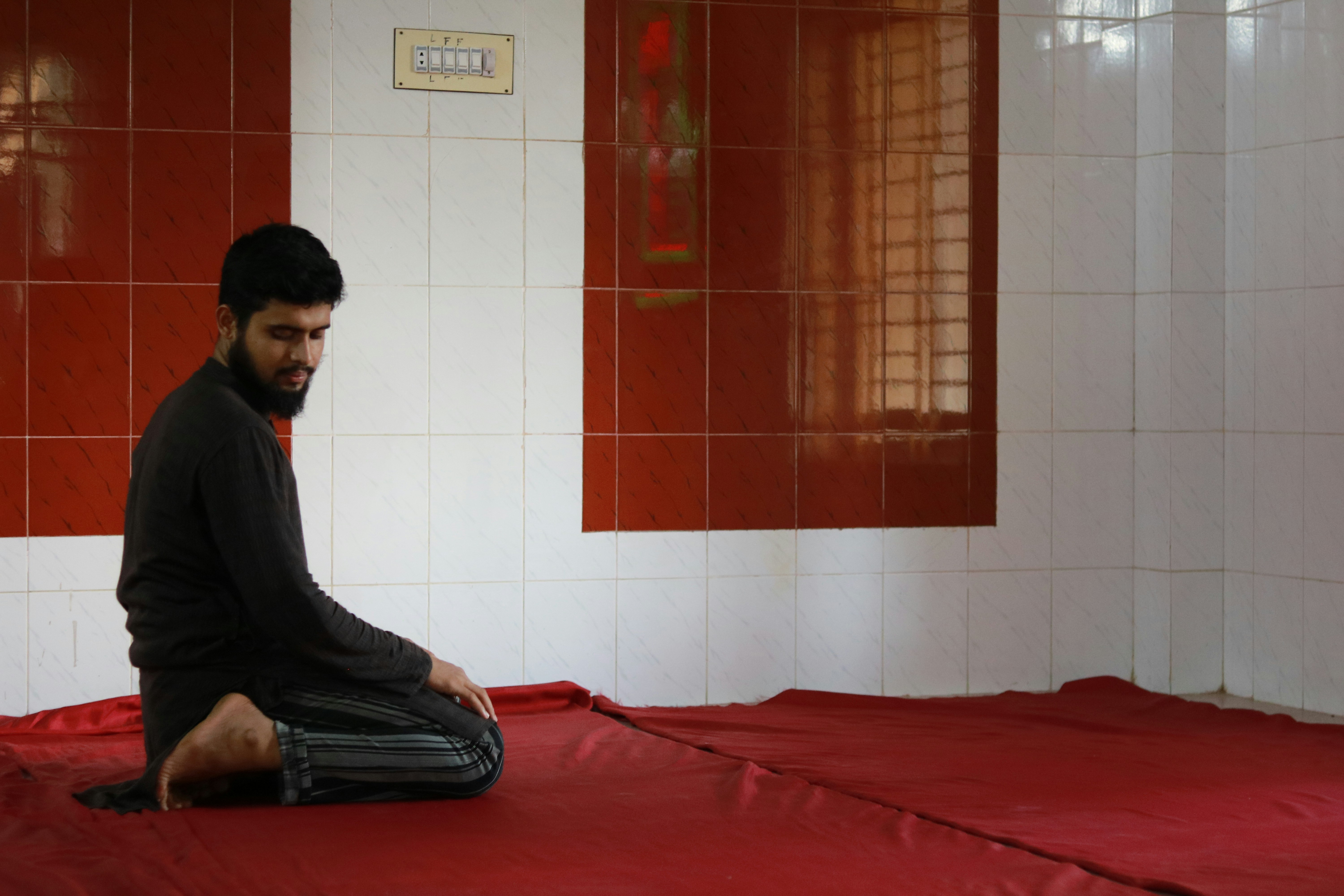 Prayerful Quiet: A Seated Figure in Red Carpeted Hall