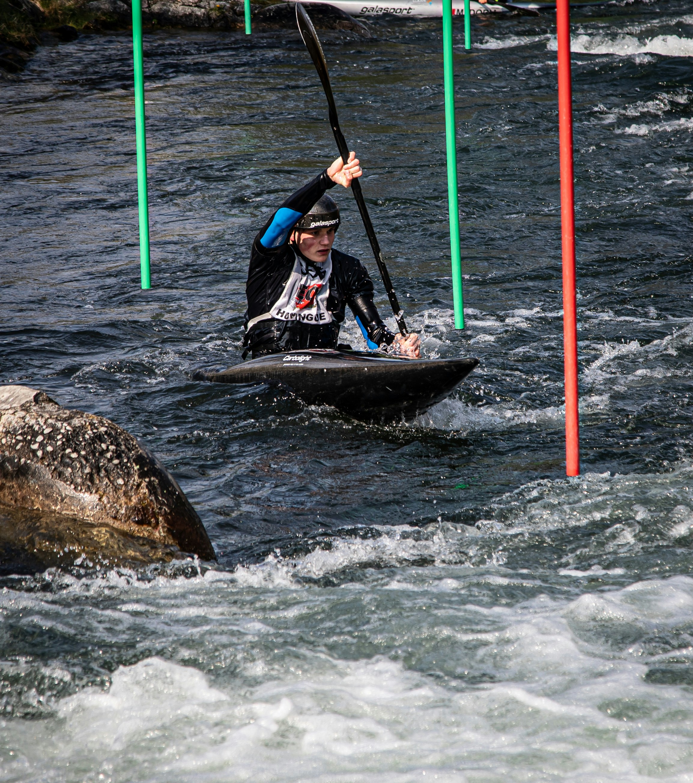 Sunlit Kayak Sprint Through Gates on Whitewater