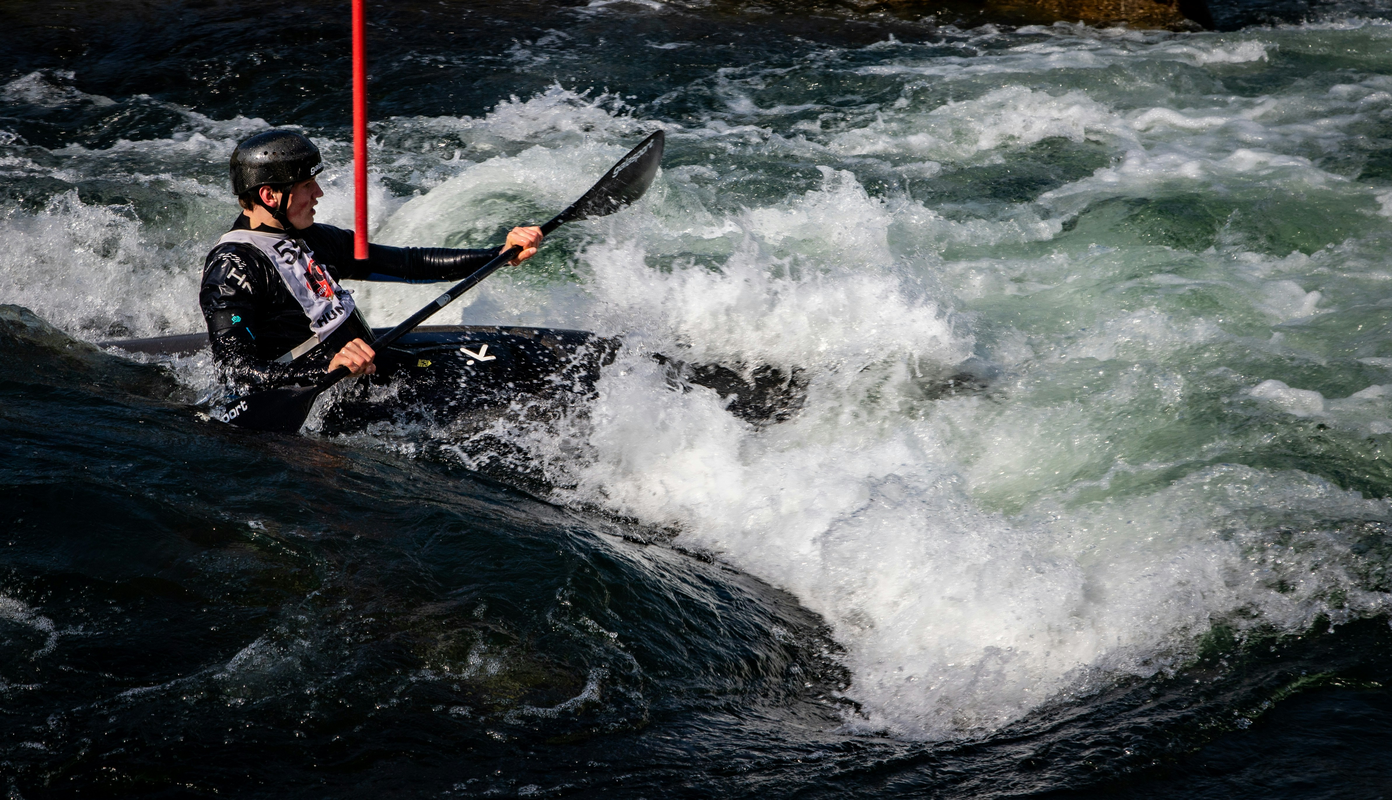 Rush of Whitewater: Kayaker Piercing Through a Curtain of Spray