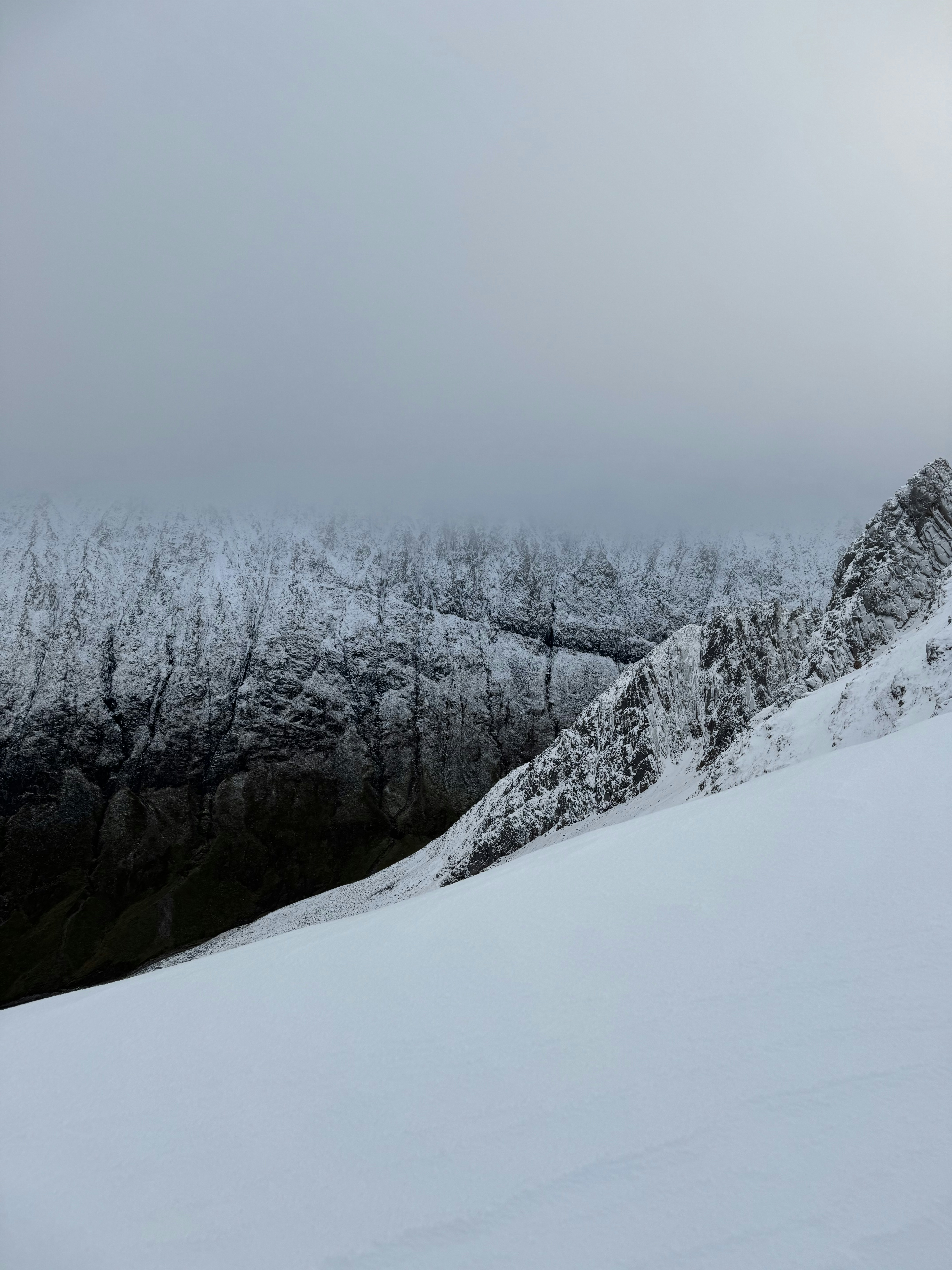 Snow-clad ridge under a quiet, pale sky