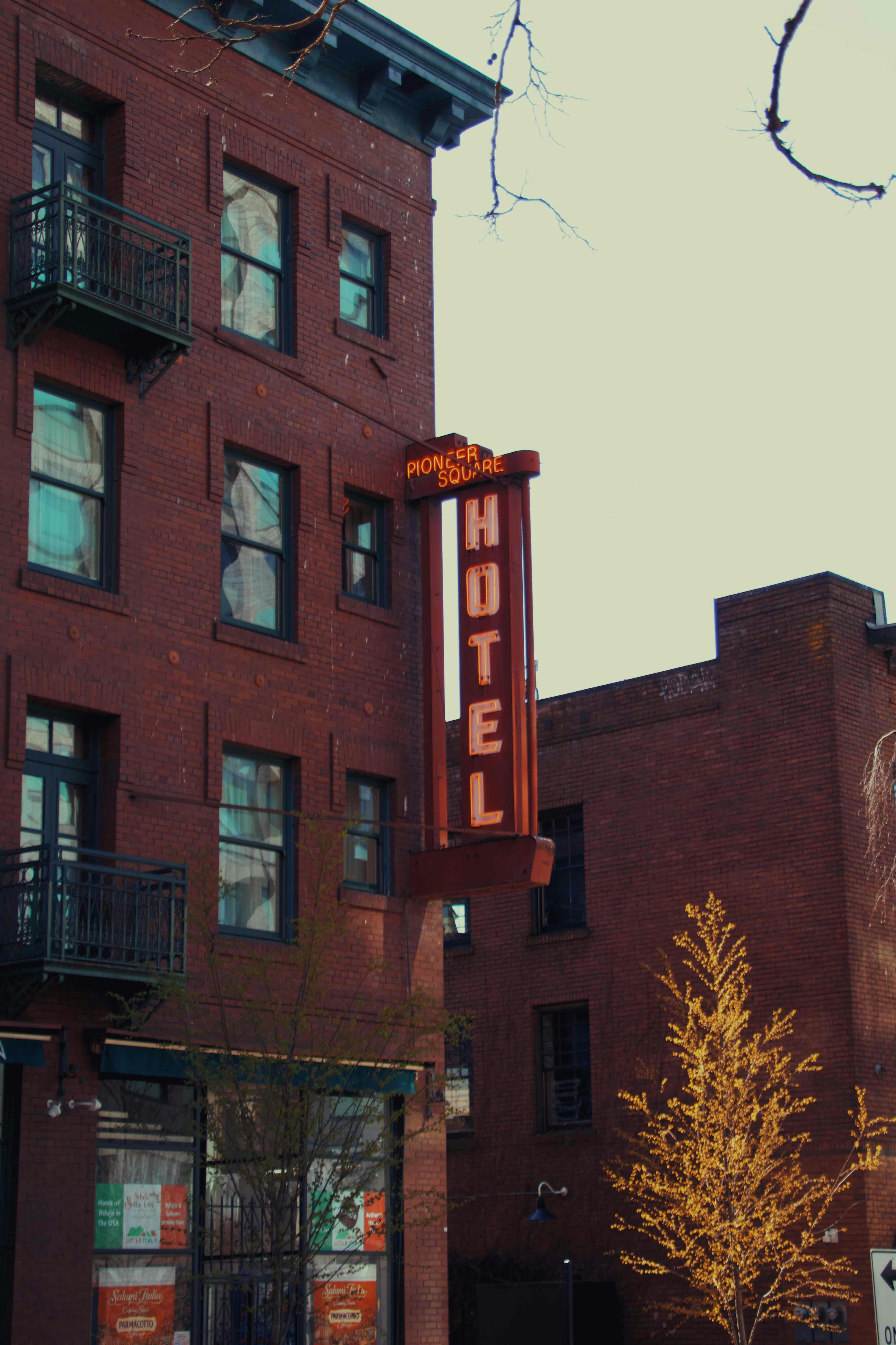 Neon Sign on Brick: A City Hotel’s Quiet Corner