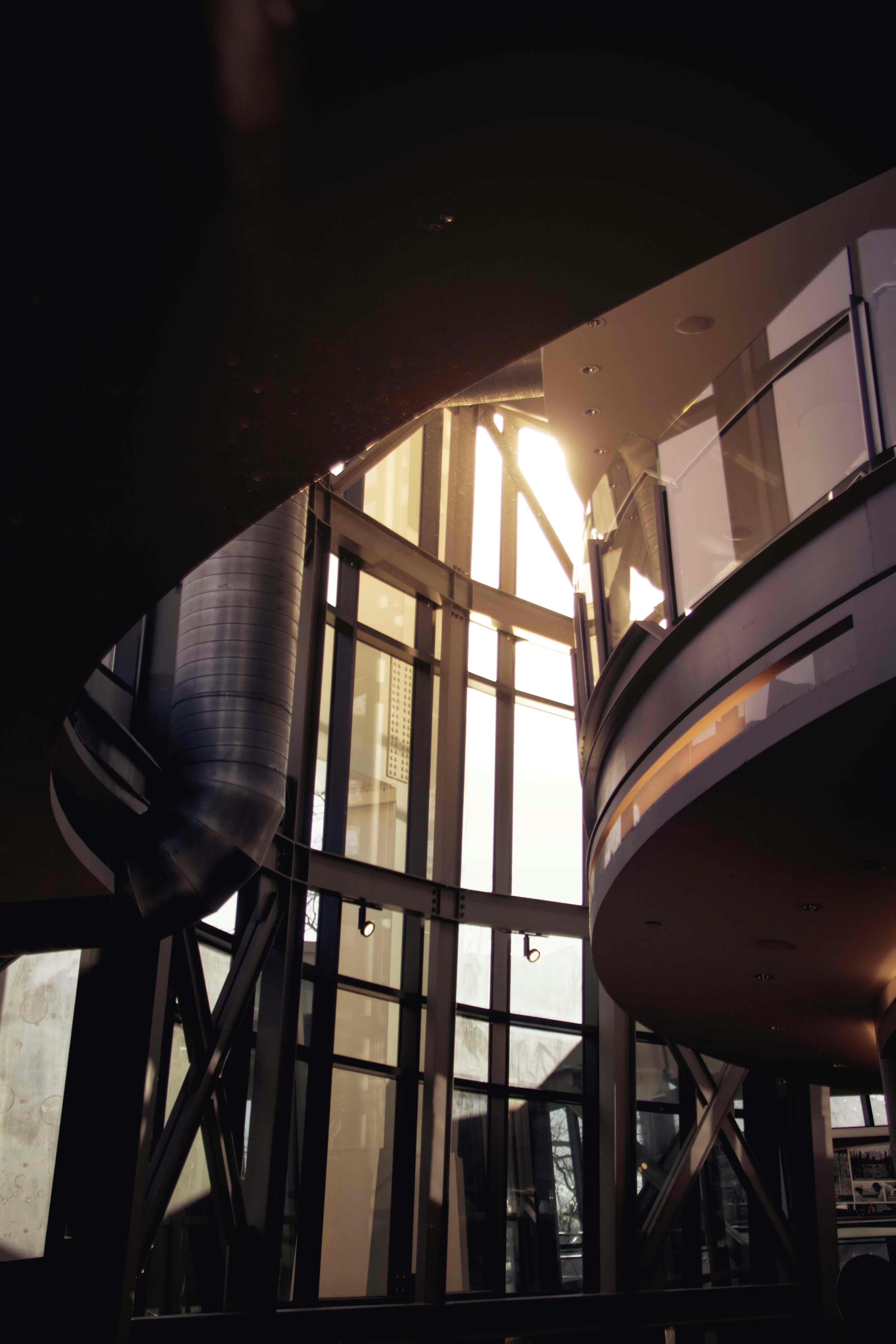 Curved Glass Atrium: Light Cascades Through Steel Skeleton