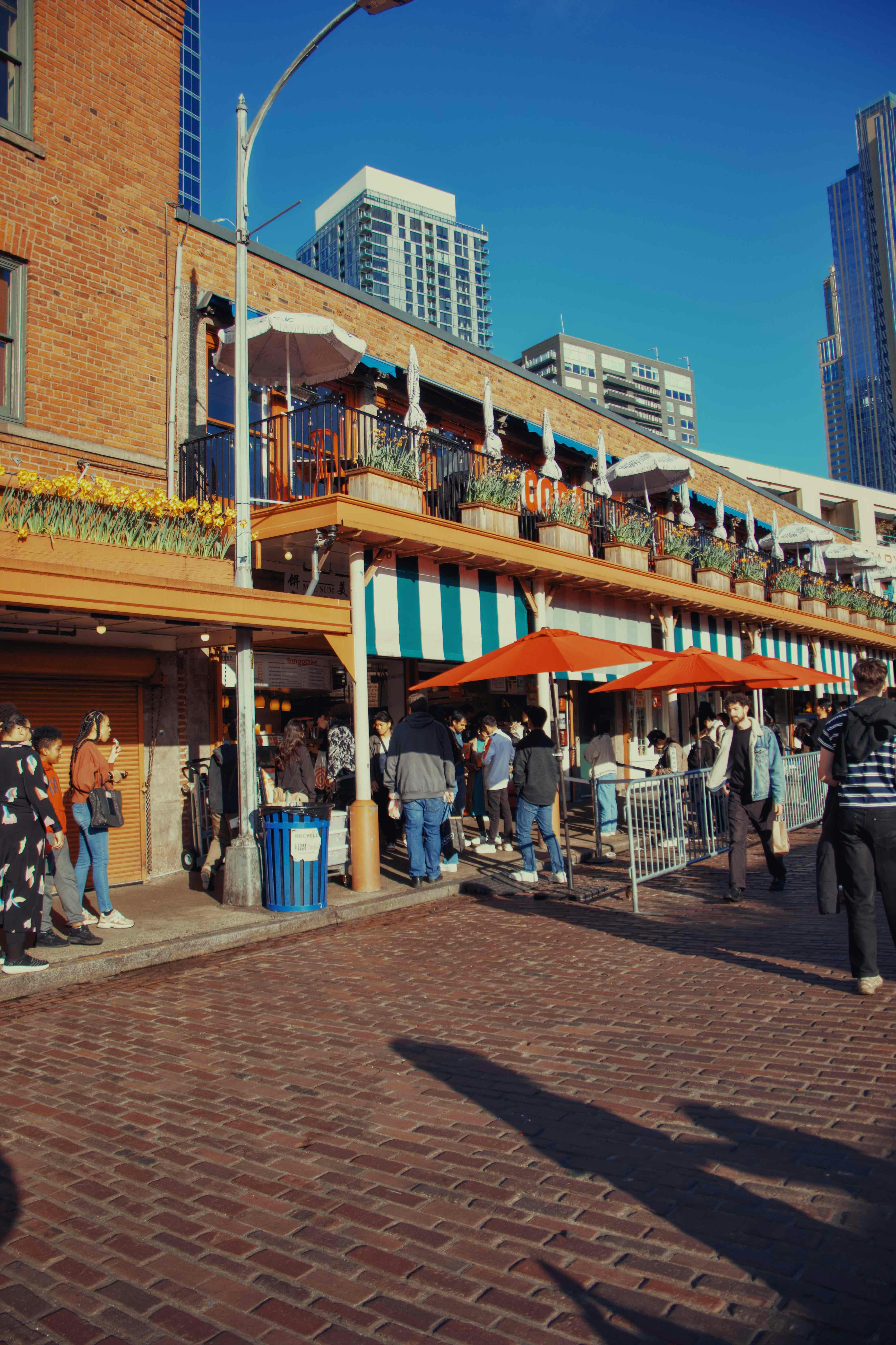 Urban Market Palette: Striped Canopies and Orange Awnings on a Brick Terrace
