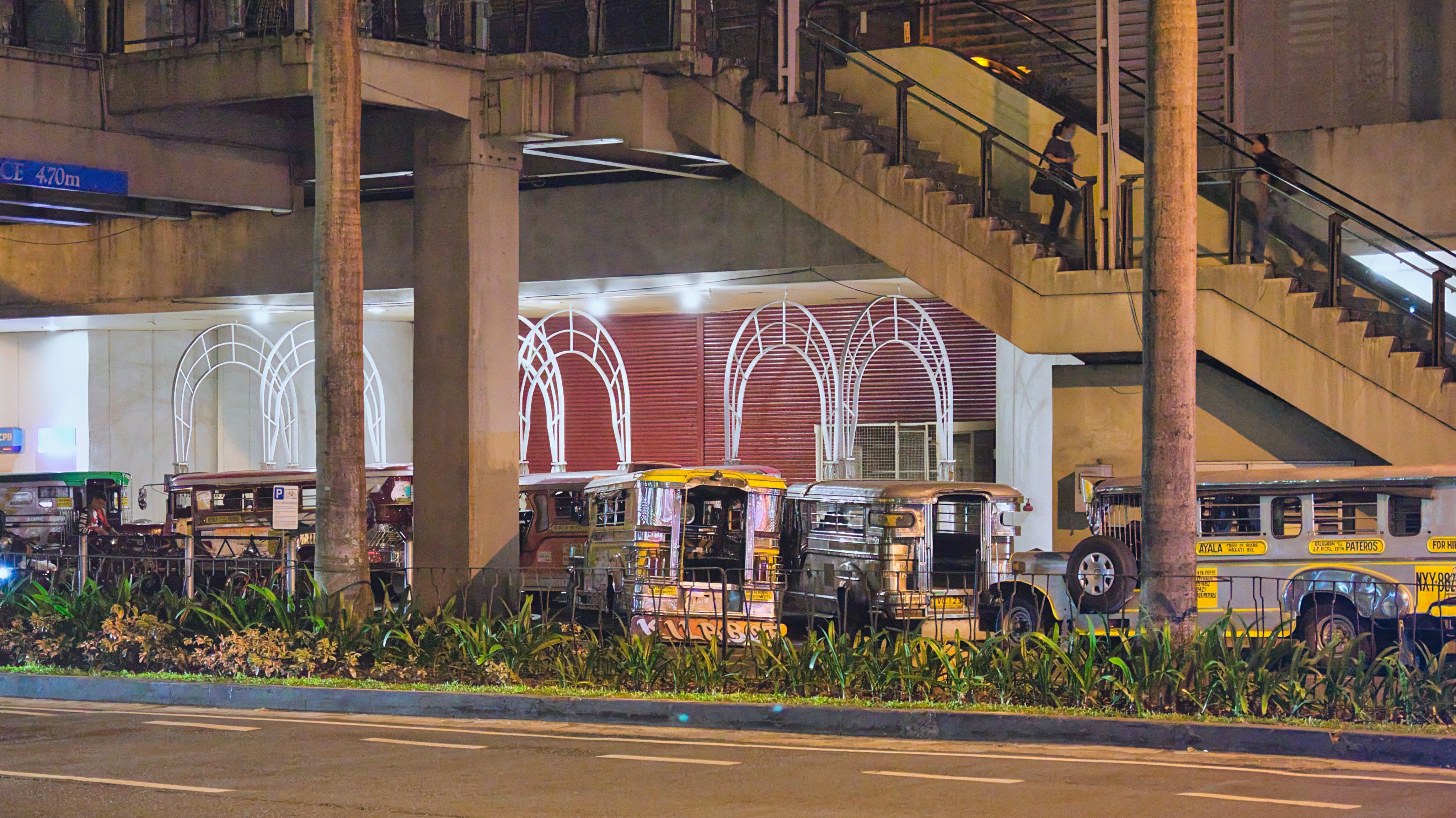 Night Street at a Transit Hub: Neon Arches and Idle Buses