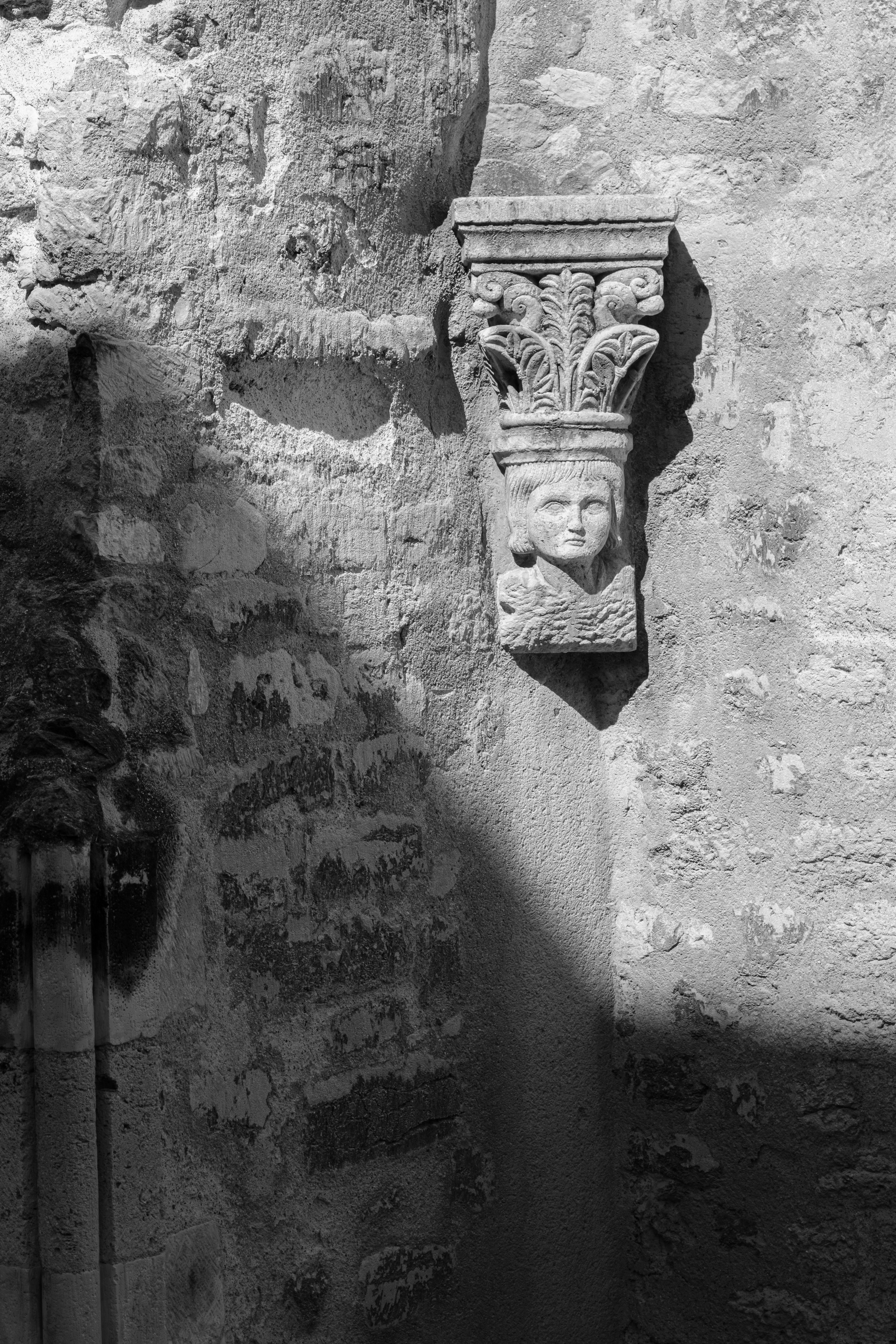 Chiseled Carved Face in Stone: A Quiet Shadow on the Wall