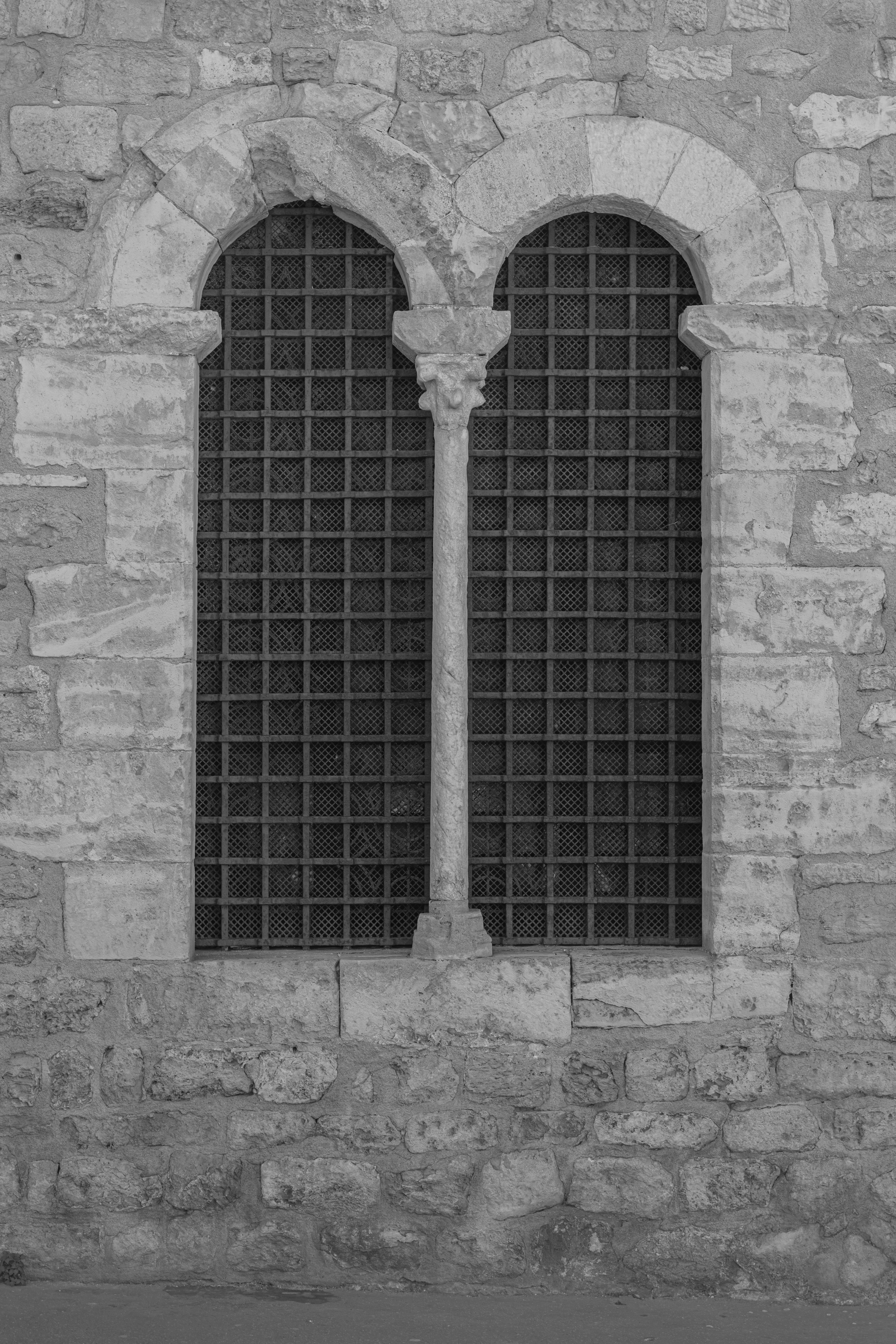 Stone Arched Window with Central Pillar in Monochrome Facade