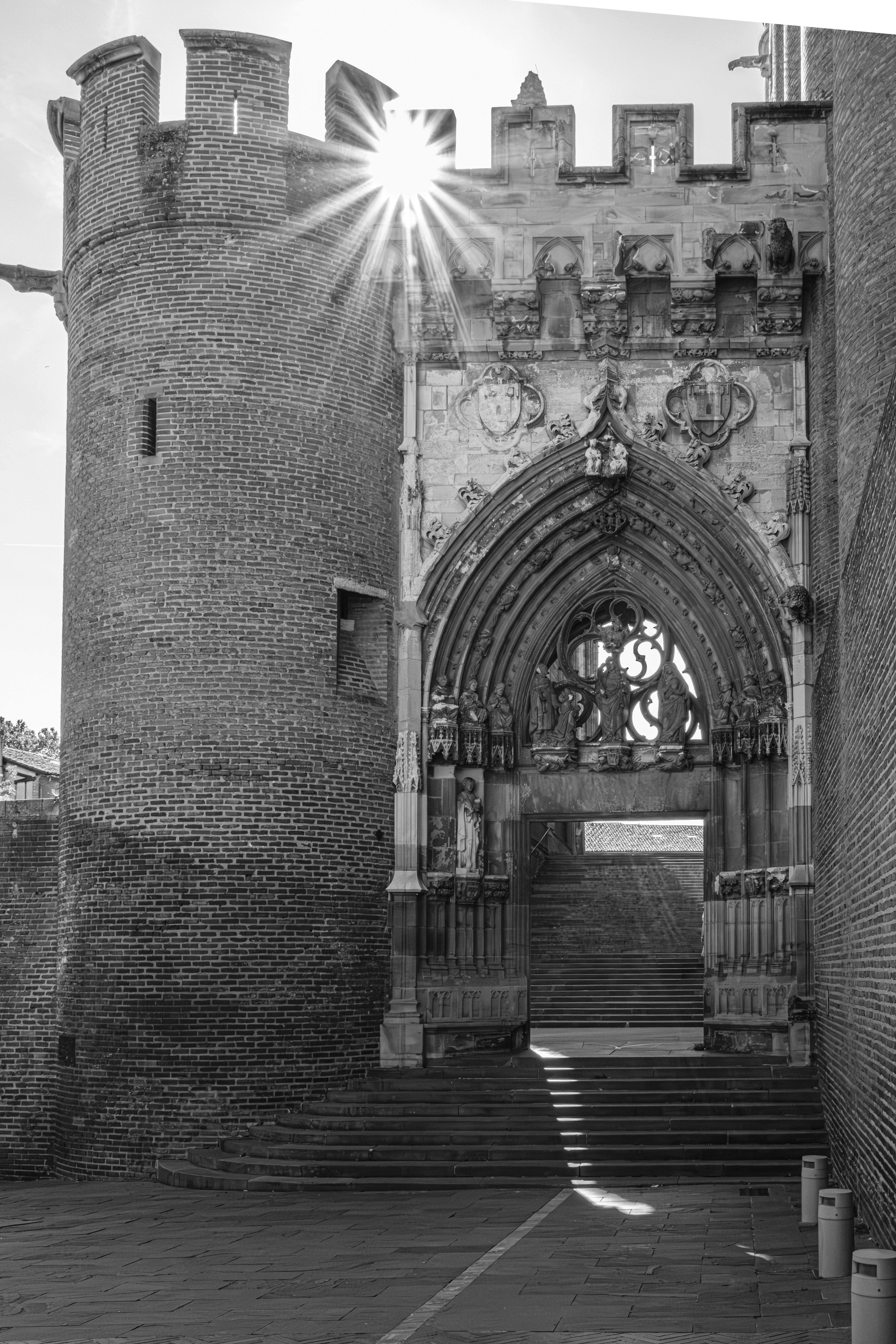 Sunlit Gothic Gate: Stone Archway Framed by Tower