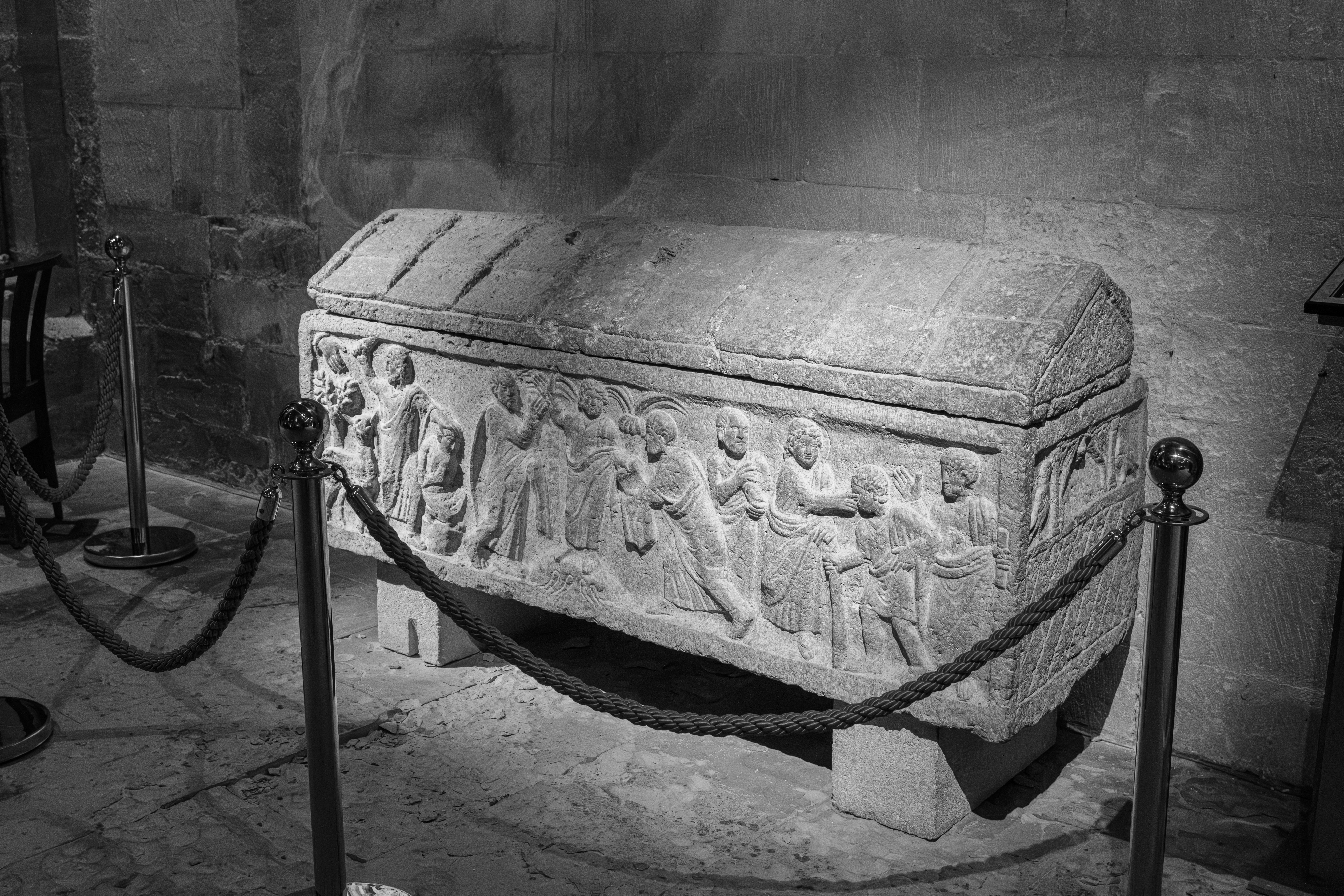 Carved ancient sarcophagus in a roped-off exhibit hall