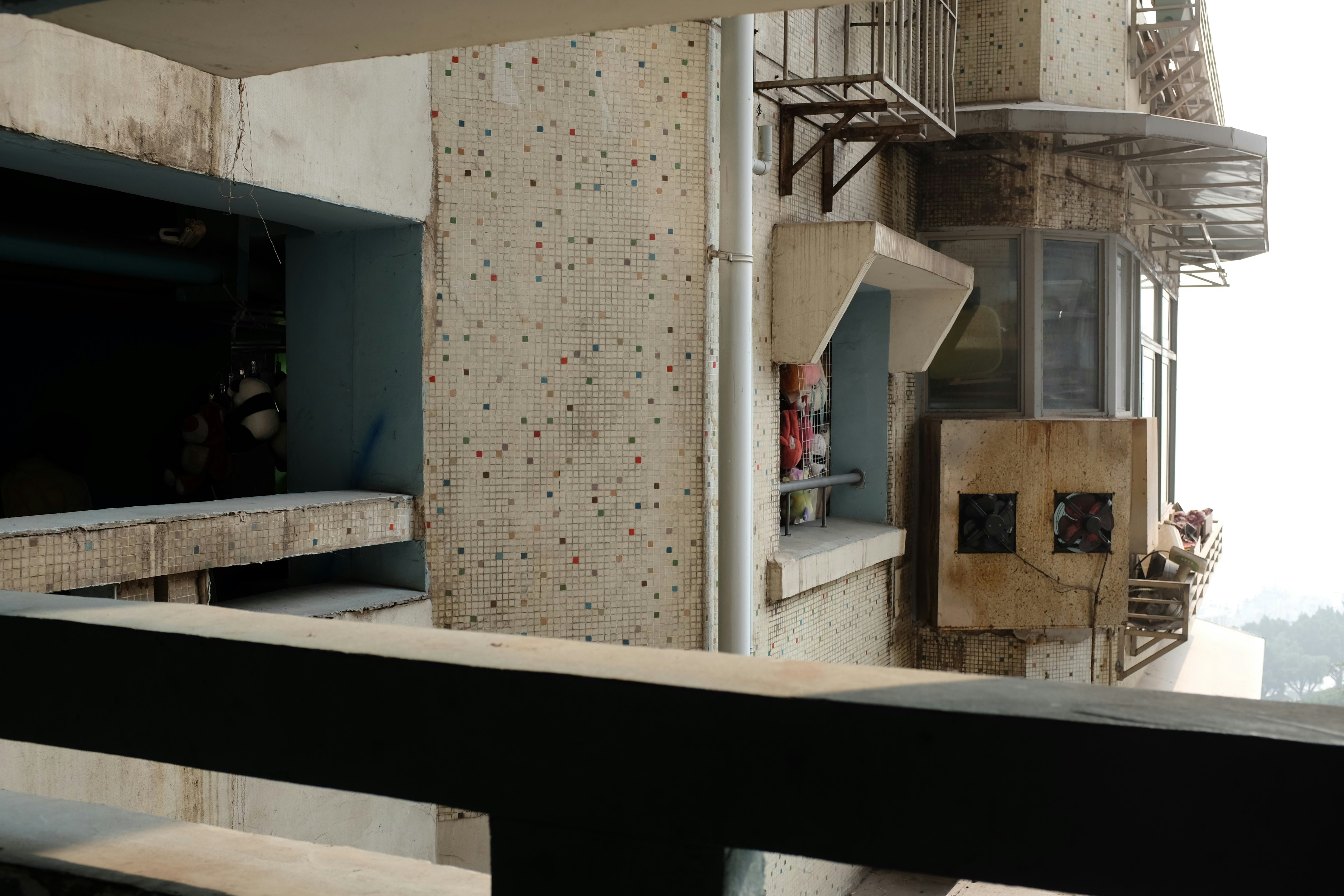 Concrete Facade with Dotted Mosaic and Balcony Overhang