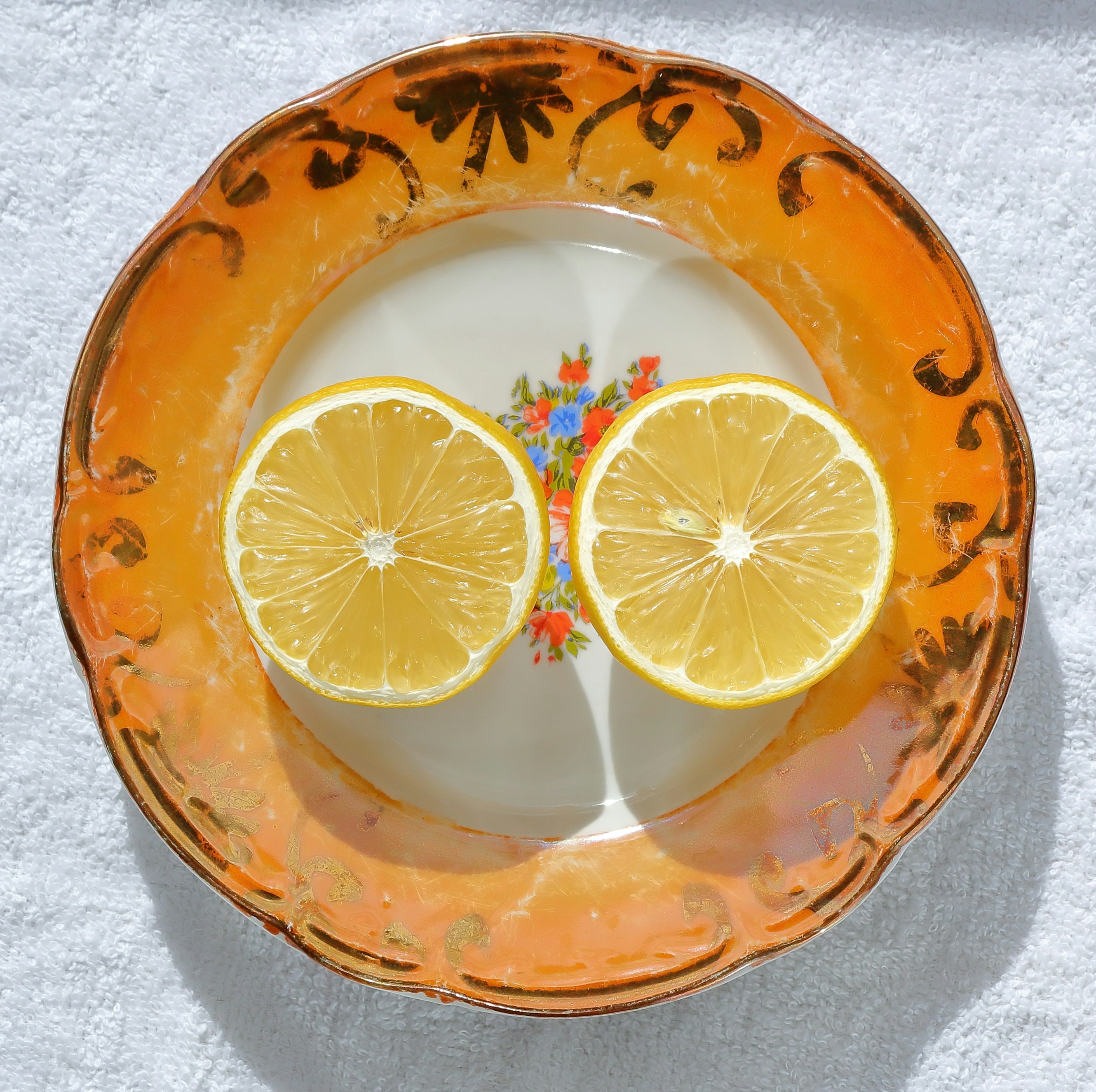 Citrus Symmetry: Two Halved LemonsCentered in Ornate Plate