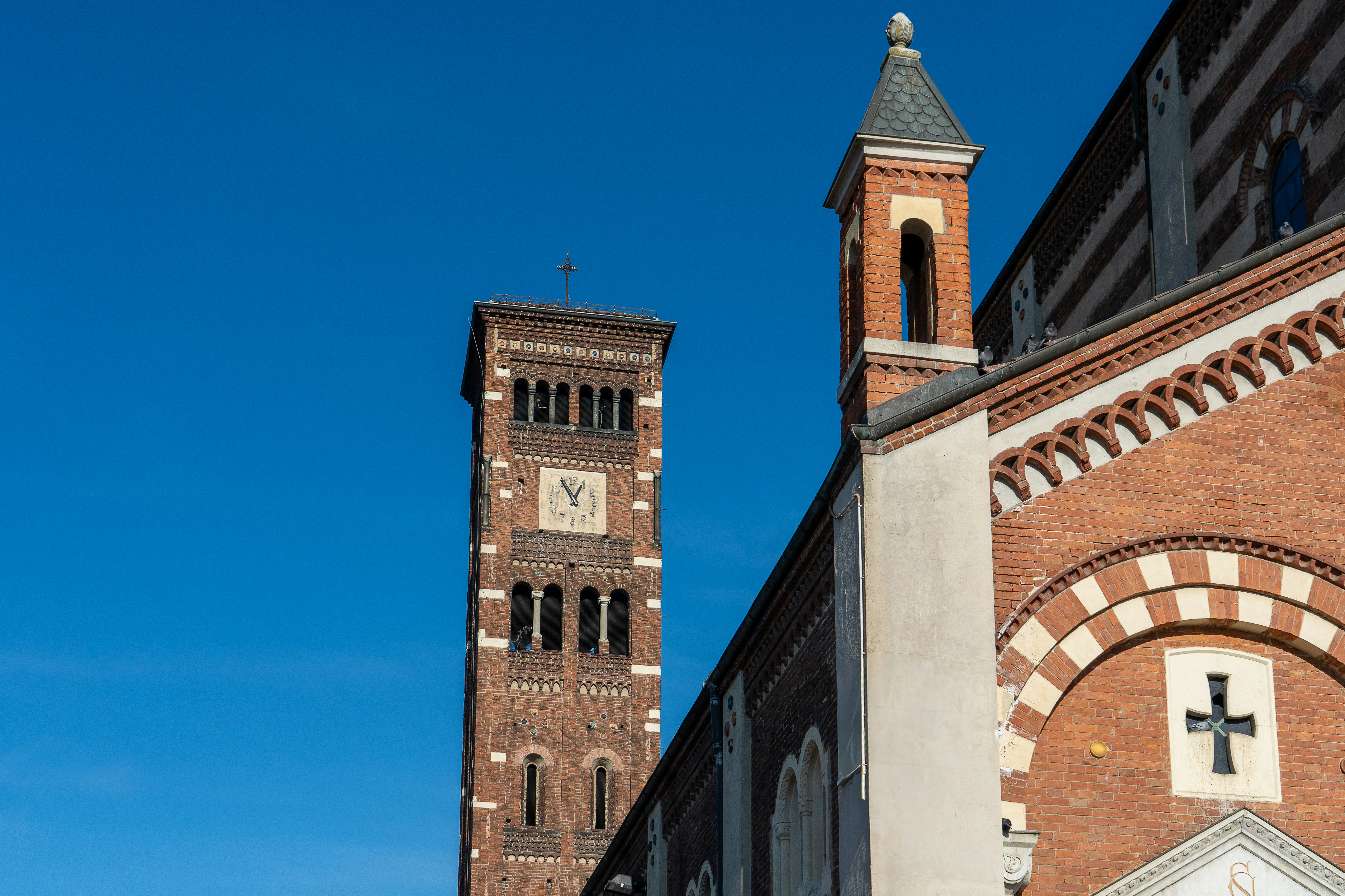 Towering Brick Clock Tower against a Clear Blue Sky