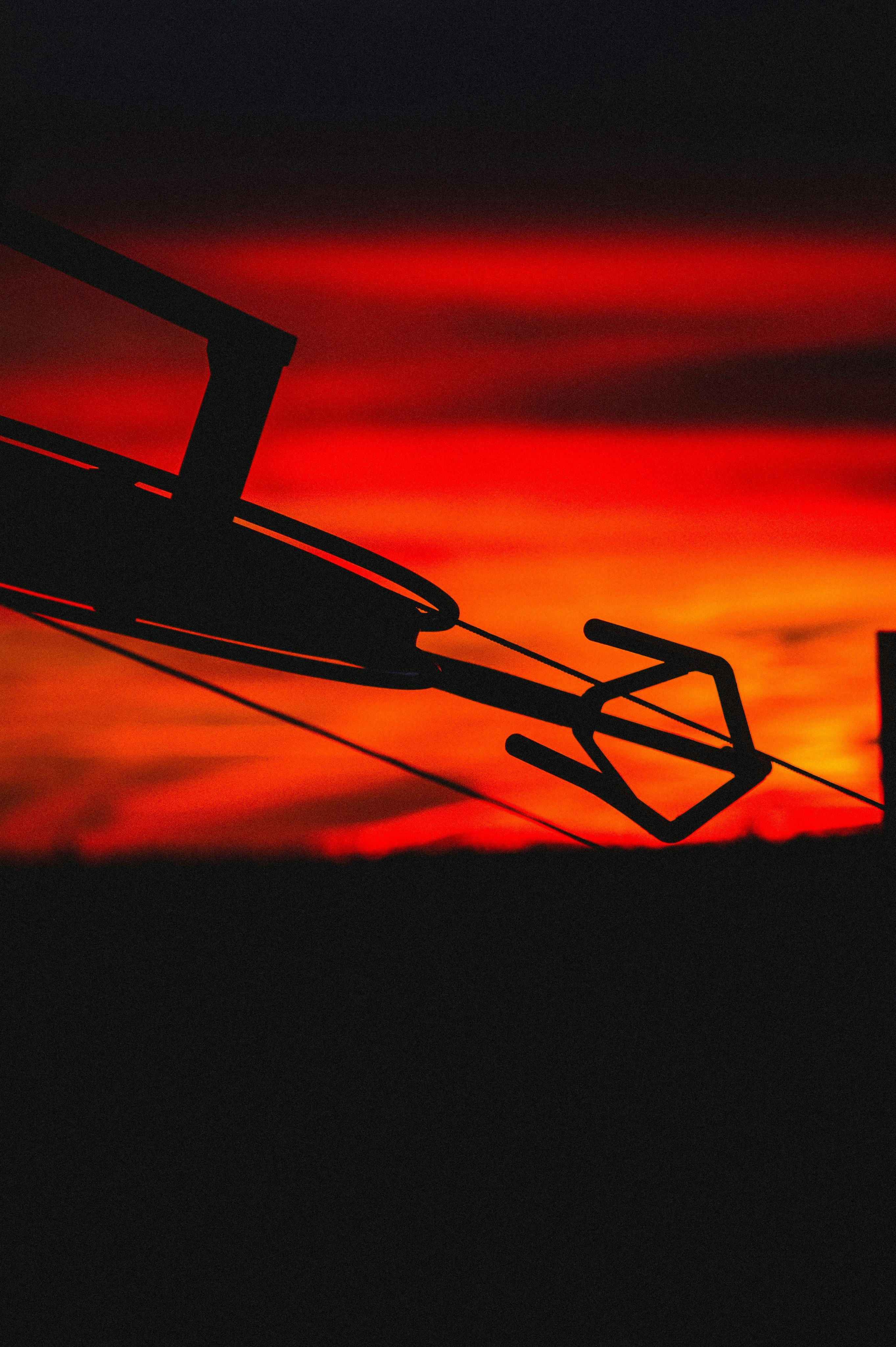 Silhouette of a Kite Tether Against a Fiery Dusk