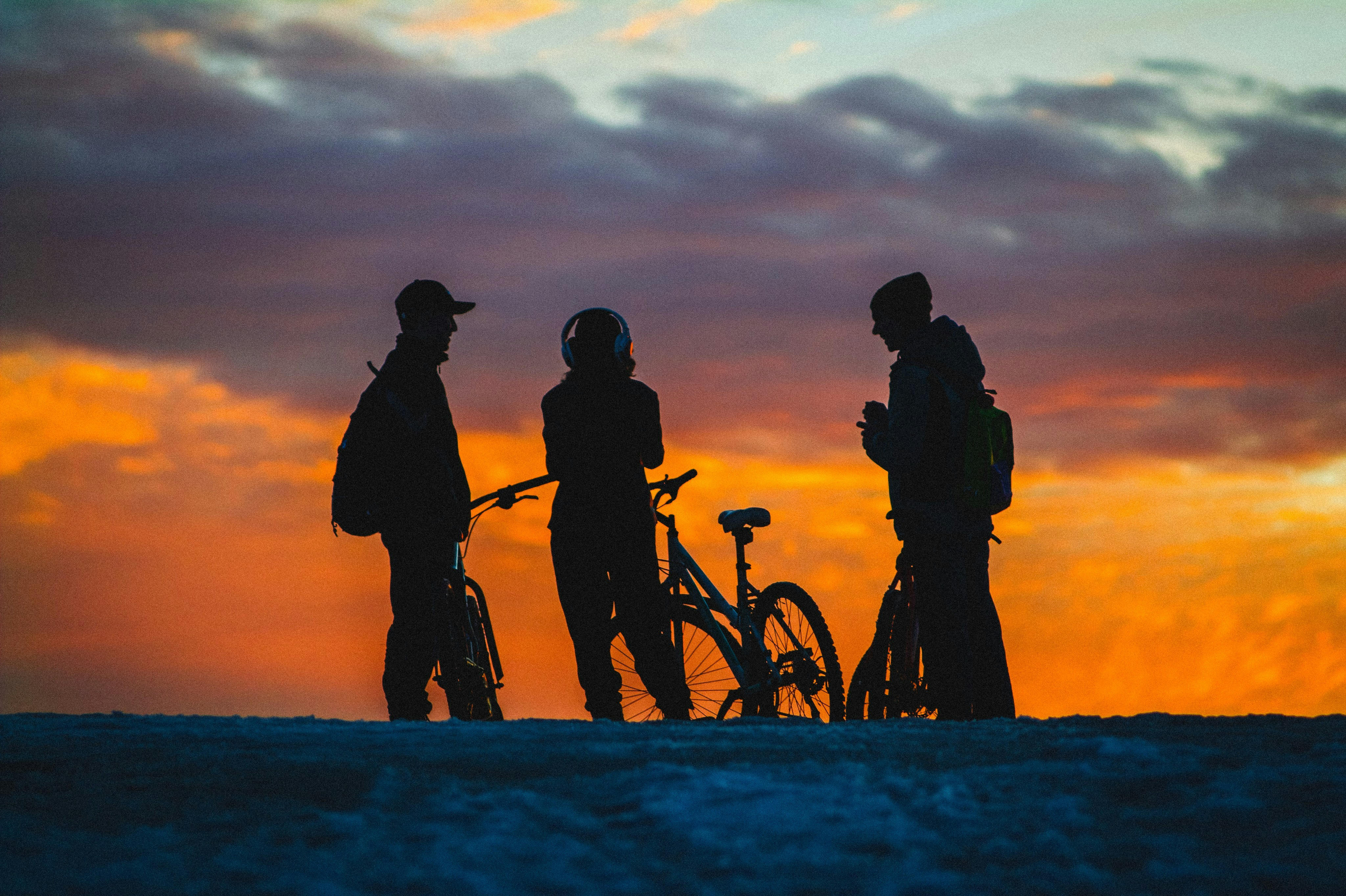 Silhouettes by the Dusk: Cyclists and a Friend on the Horizon