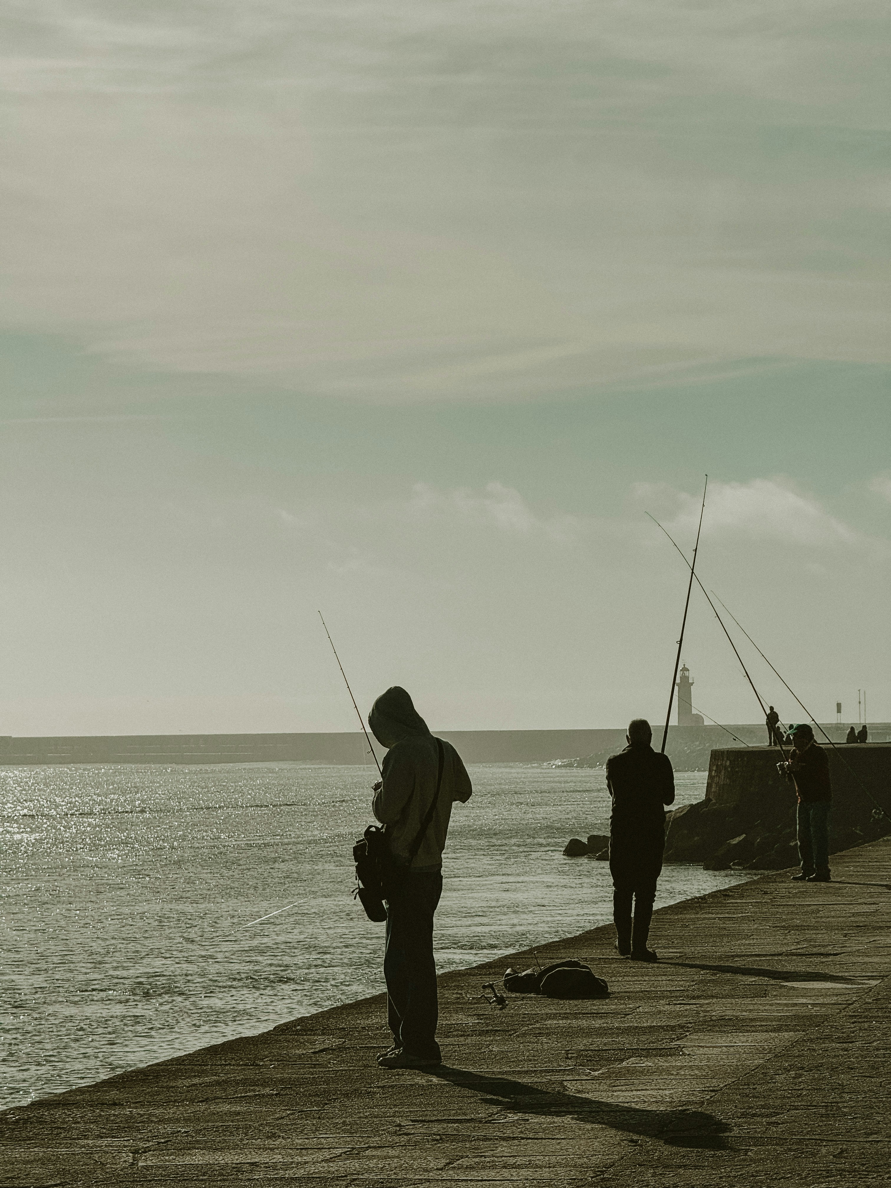 Lines of a Quiet Pier: Fishermen at Dusk By the Sea