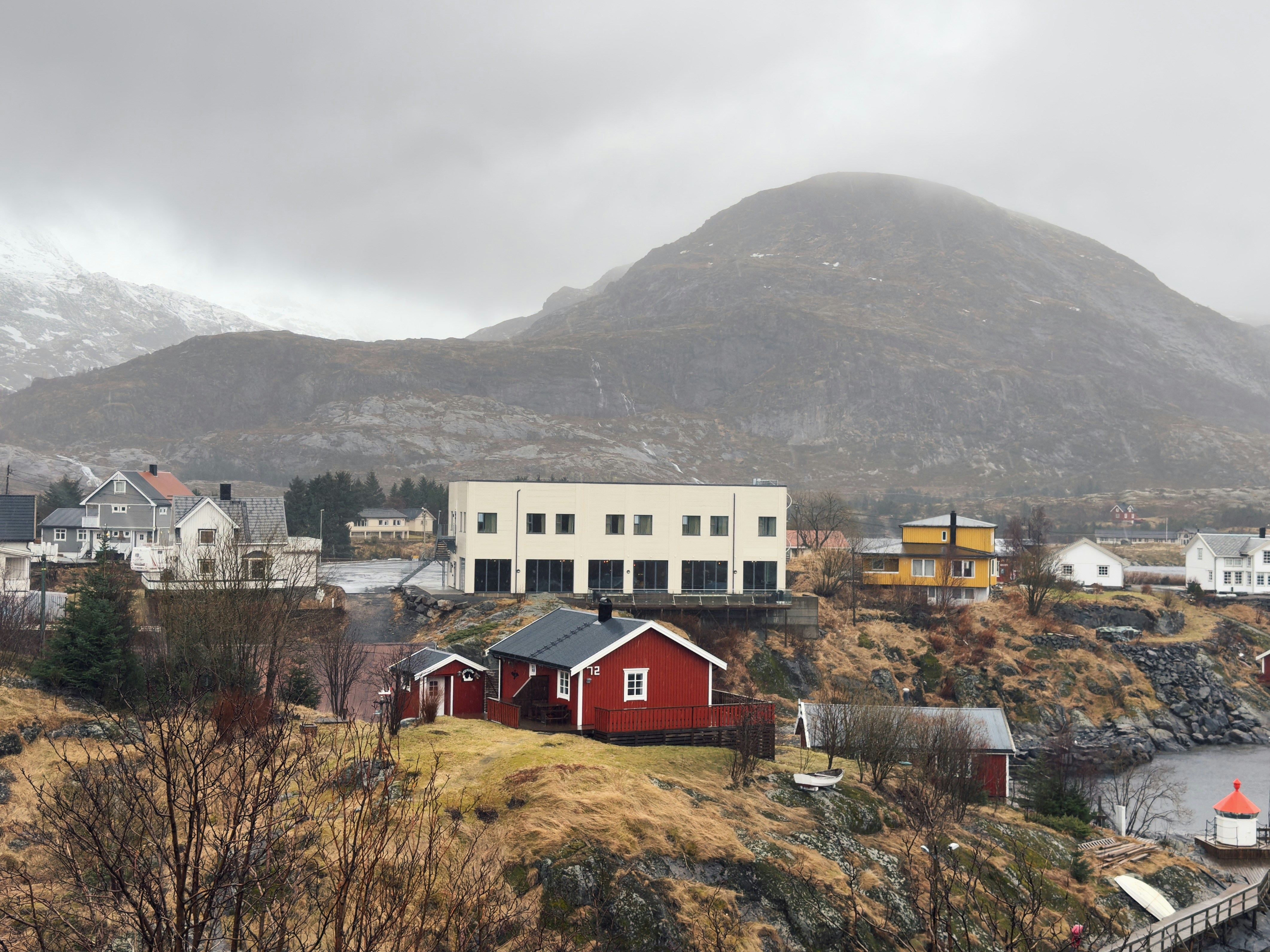 Red Boathouse Village Beneath a Misty Mountain