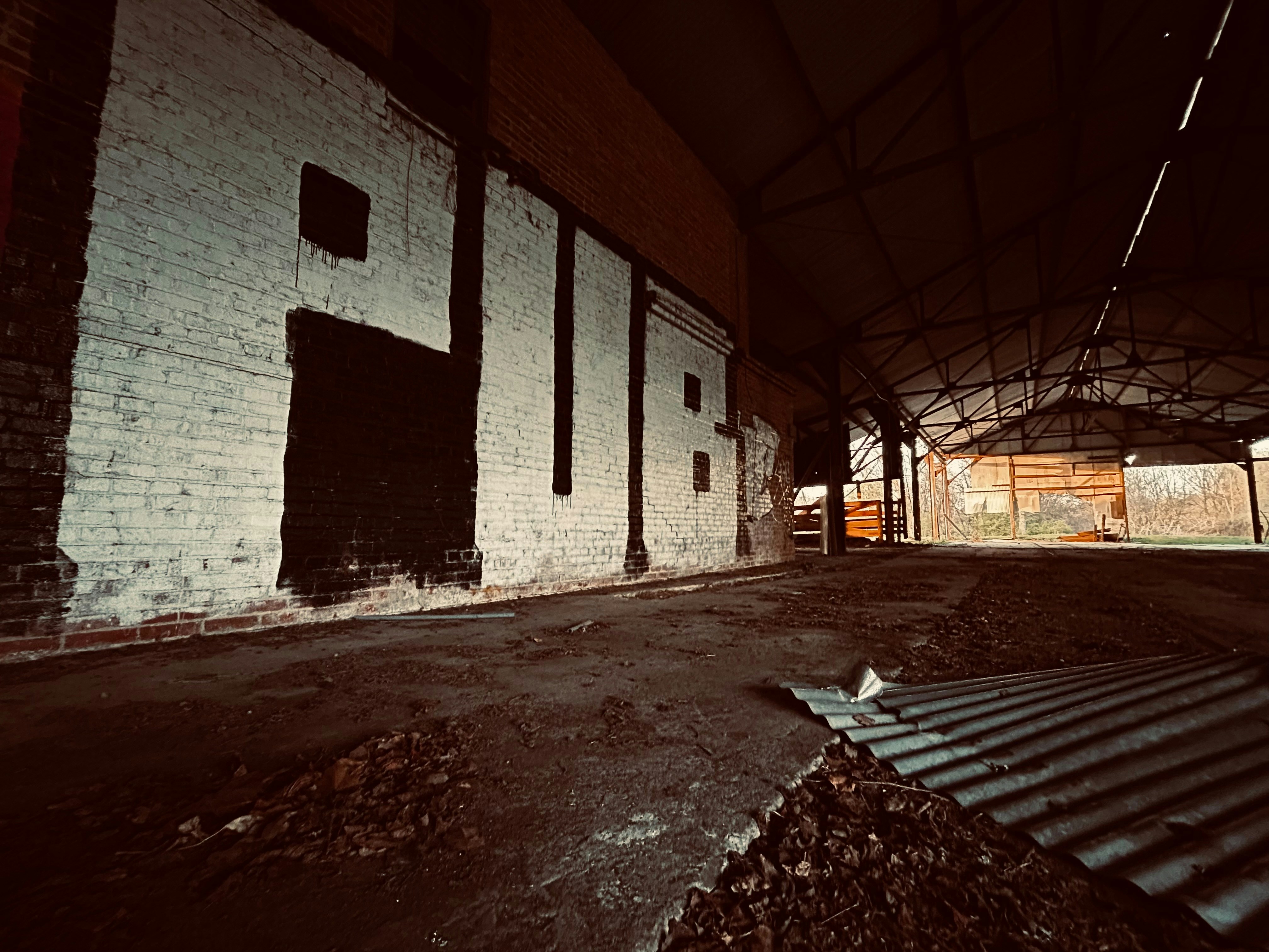 Urban Echoes: Graffitied Brick Wall Inside a Deserted Warehouse