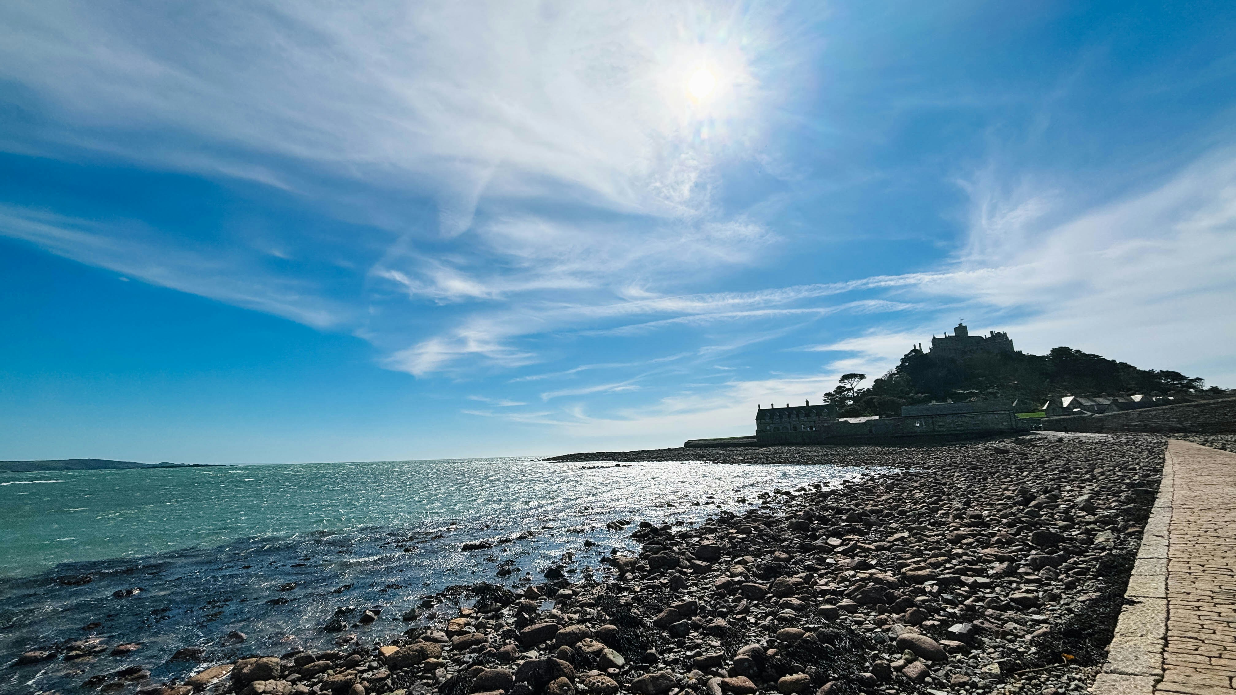Sunlit Breakwater: A Coastal Scene of Blue Sky and Quiet Stone