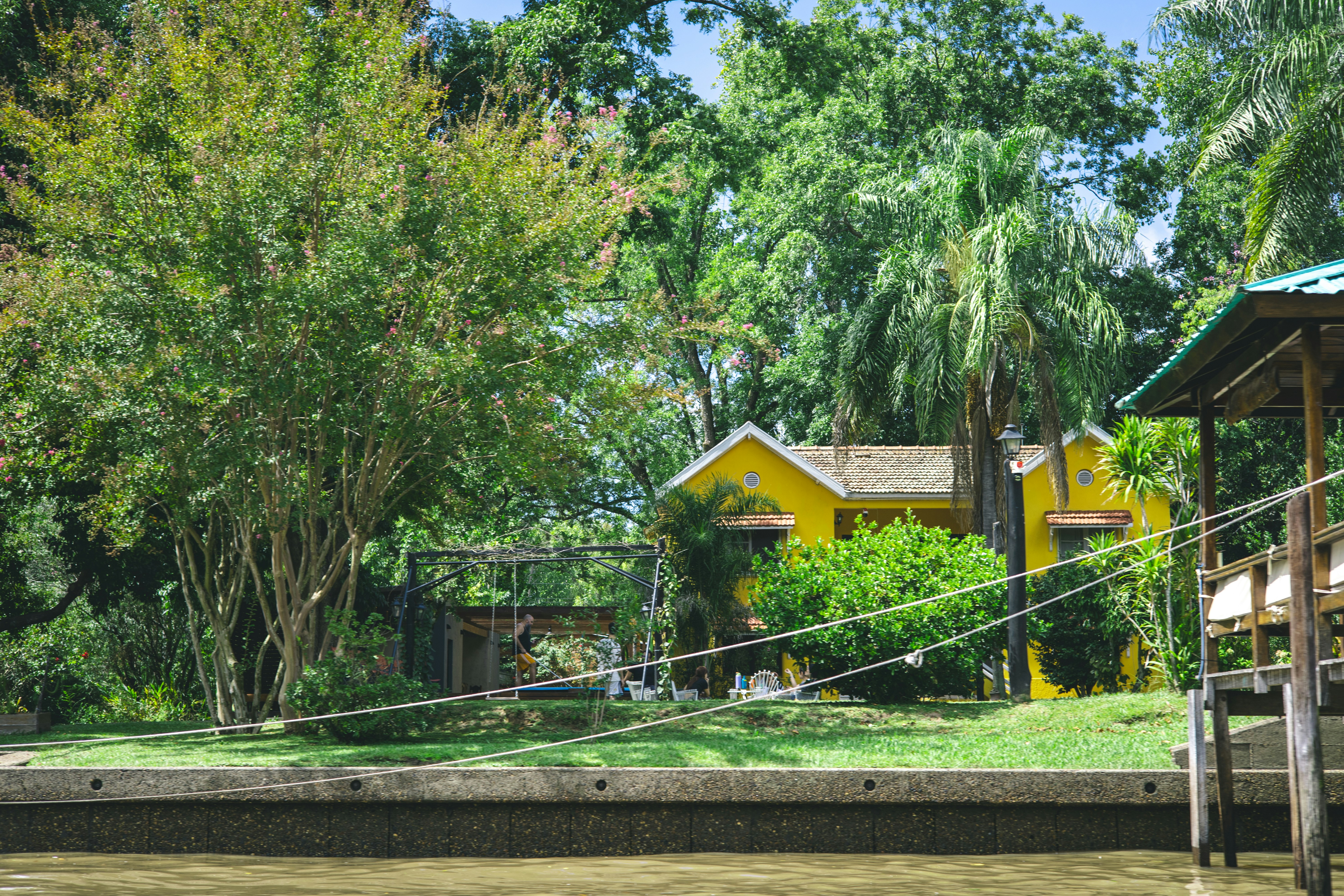Sunlit Riverside Compound with Bright Yellow House