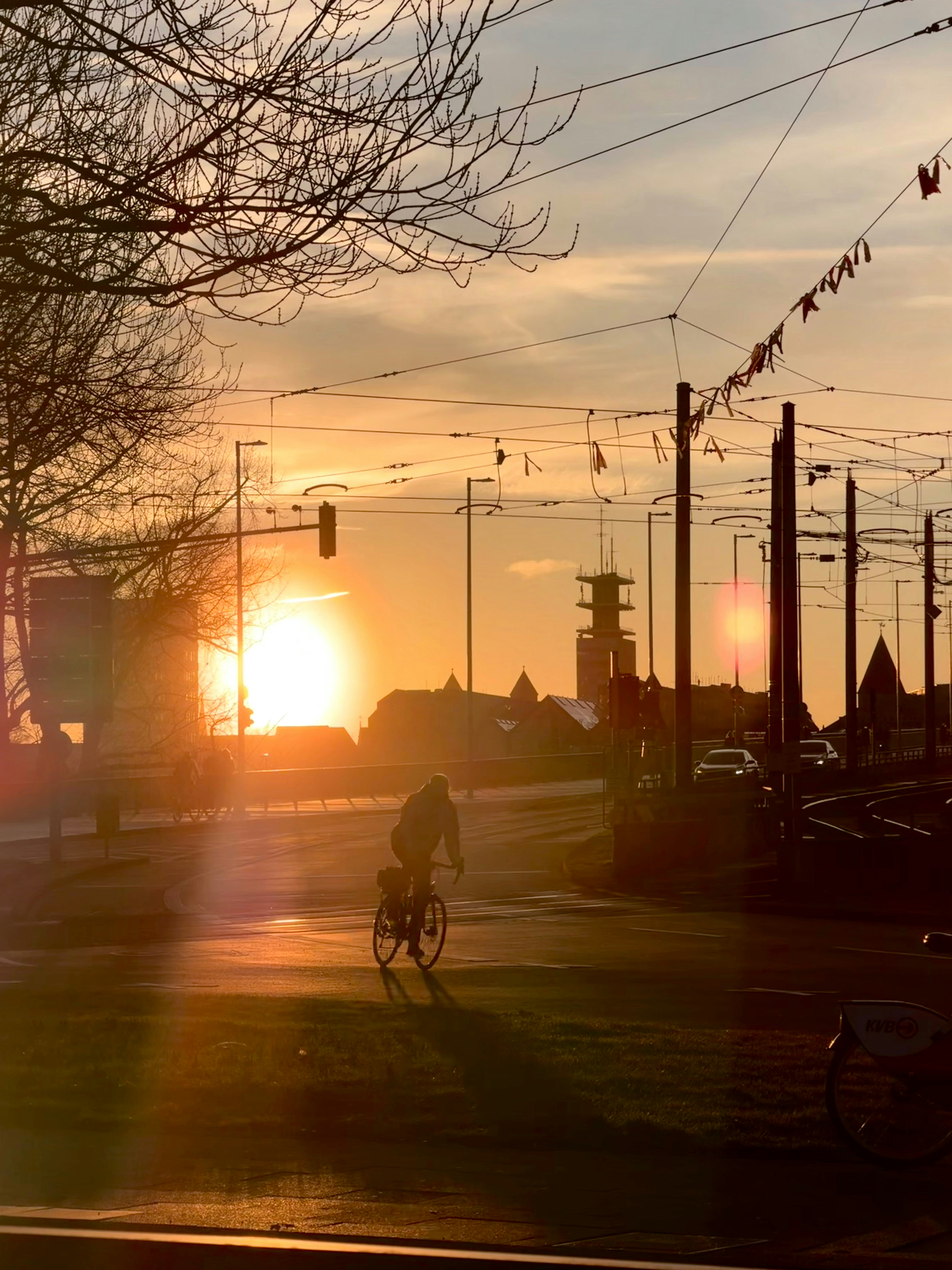 Golden Hour on Rails: Cyclist Crossing the Sunset City