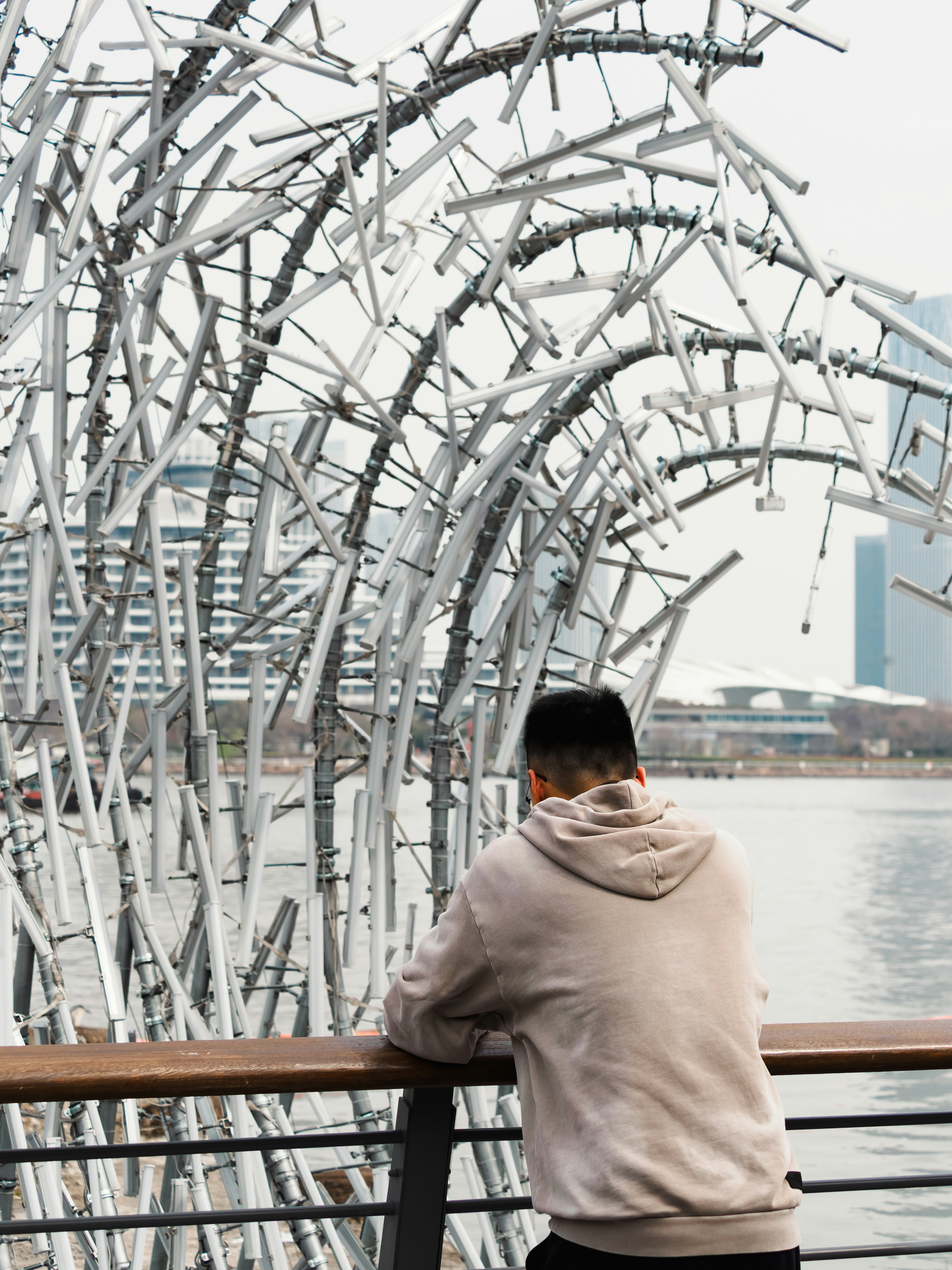 Caught Between Metal Arches: A Quiet Perspective on a Waterfront Moment