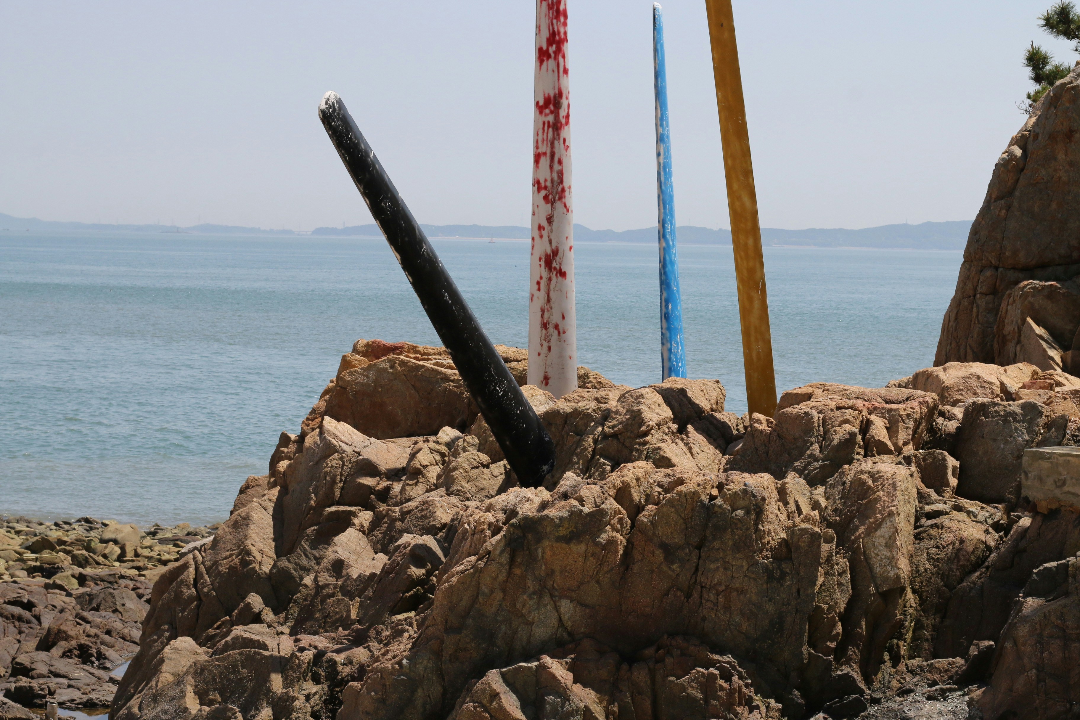 Colorful Flags Standing Guard on Weathered Rocks by the Sea