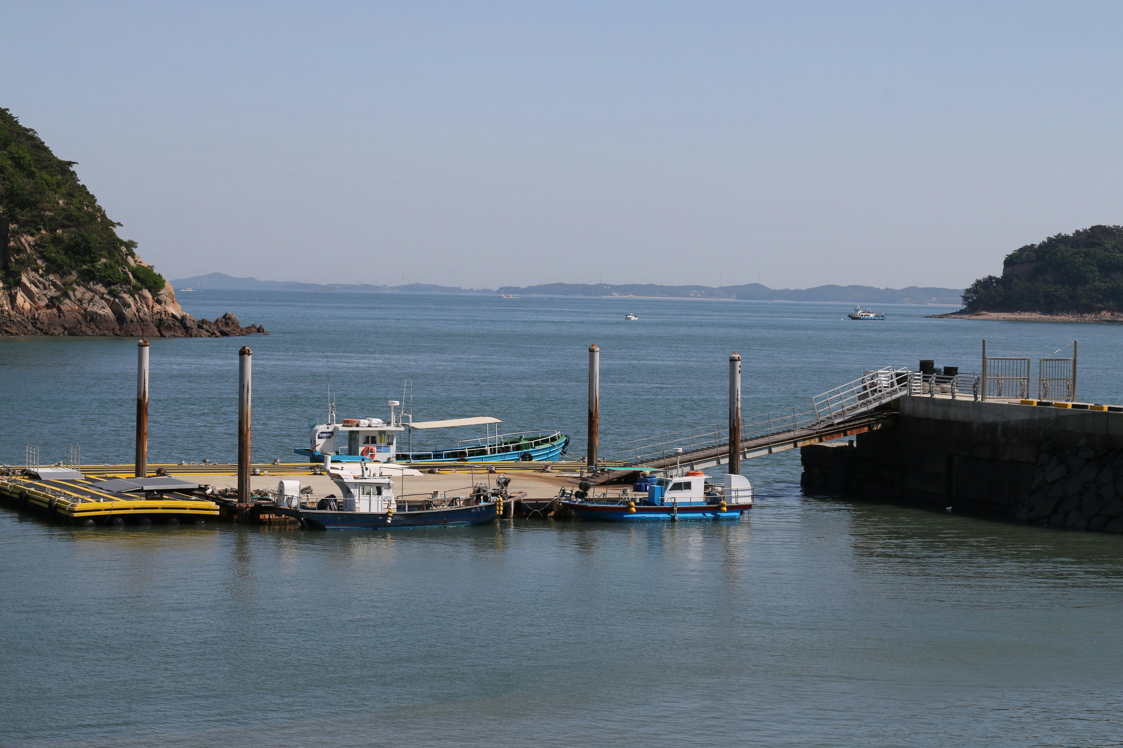 Harbor Symmetry: Boats, Ledge, and Quiet Sea
