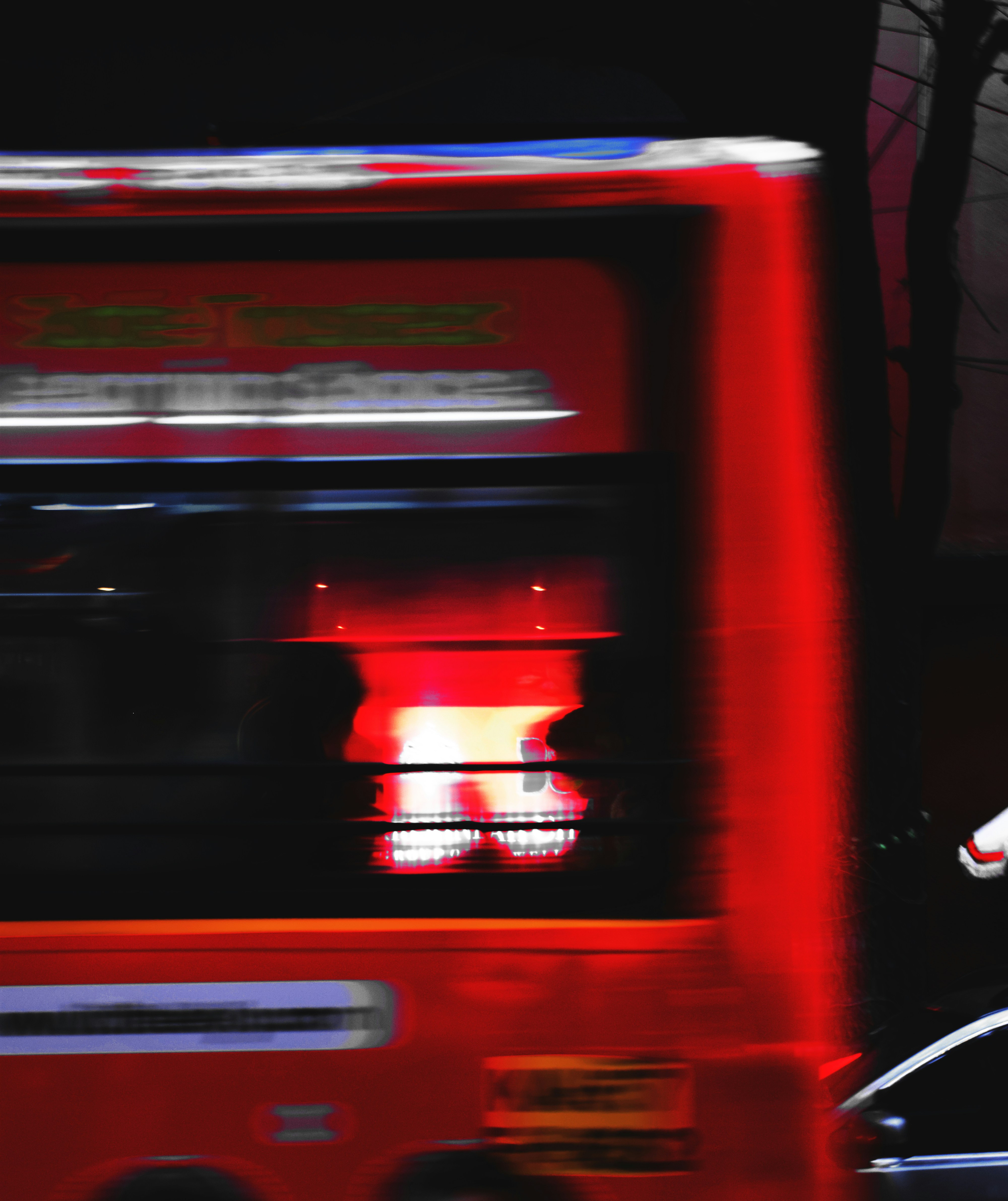 Blurred city red: motion-streak bus at night