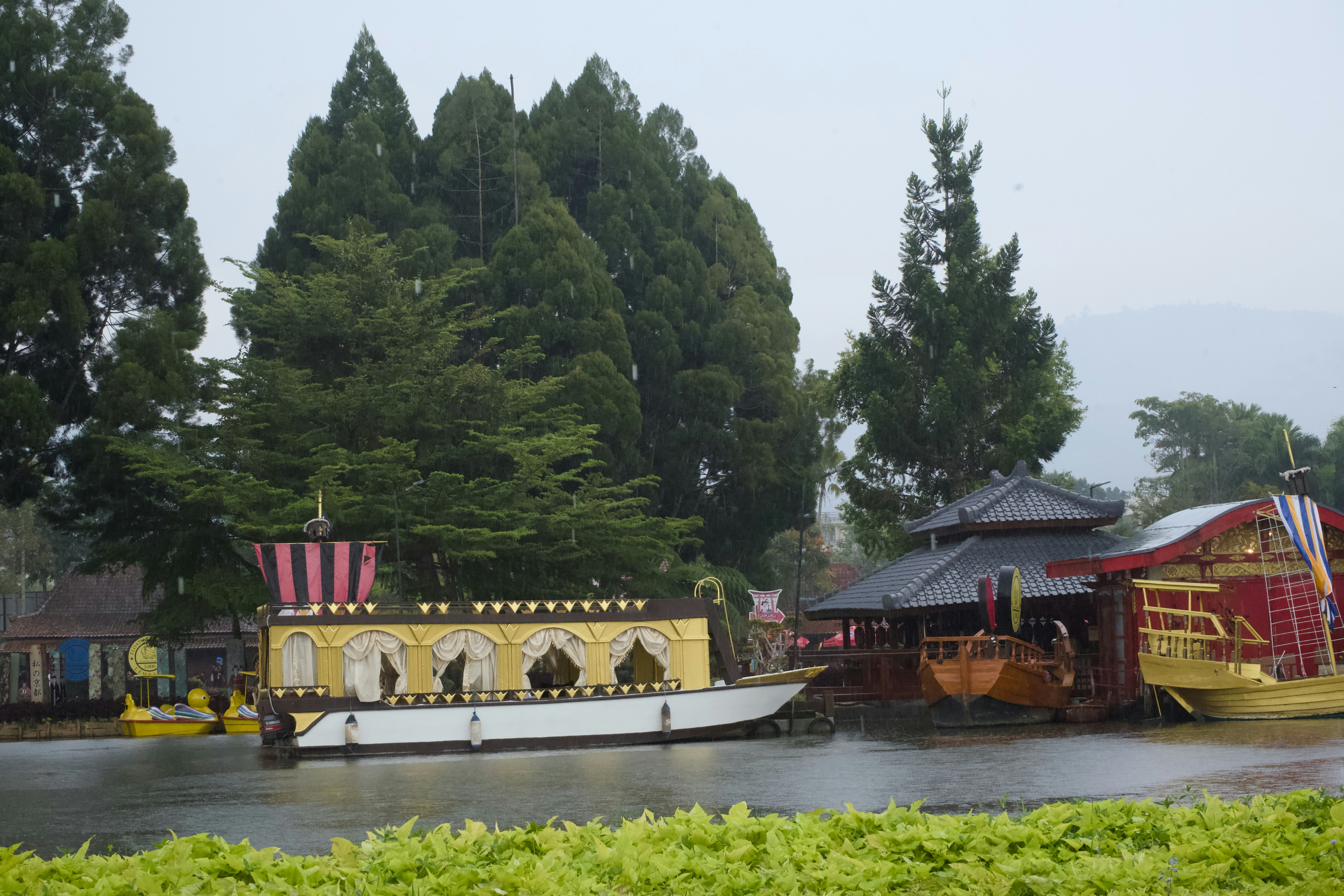 Waterfront Parade: Colorful Boats by a Shady Riverside Village