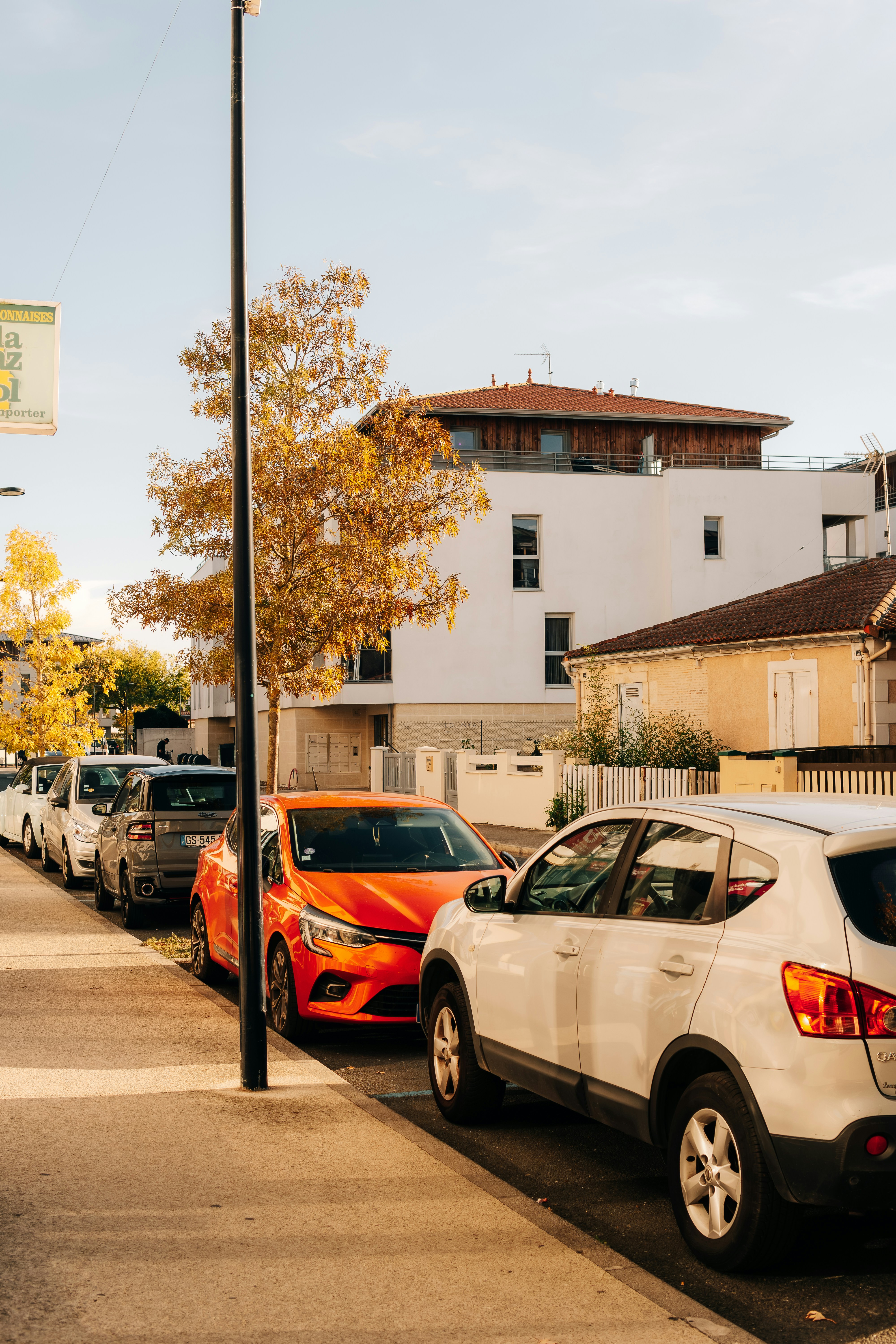 Morning Street—Sunlit Row of Cars and a White Apartment Building