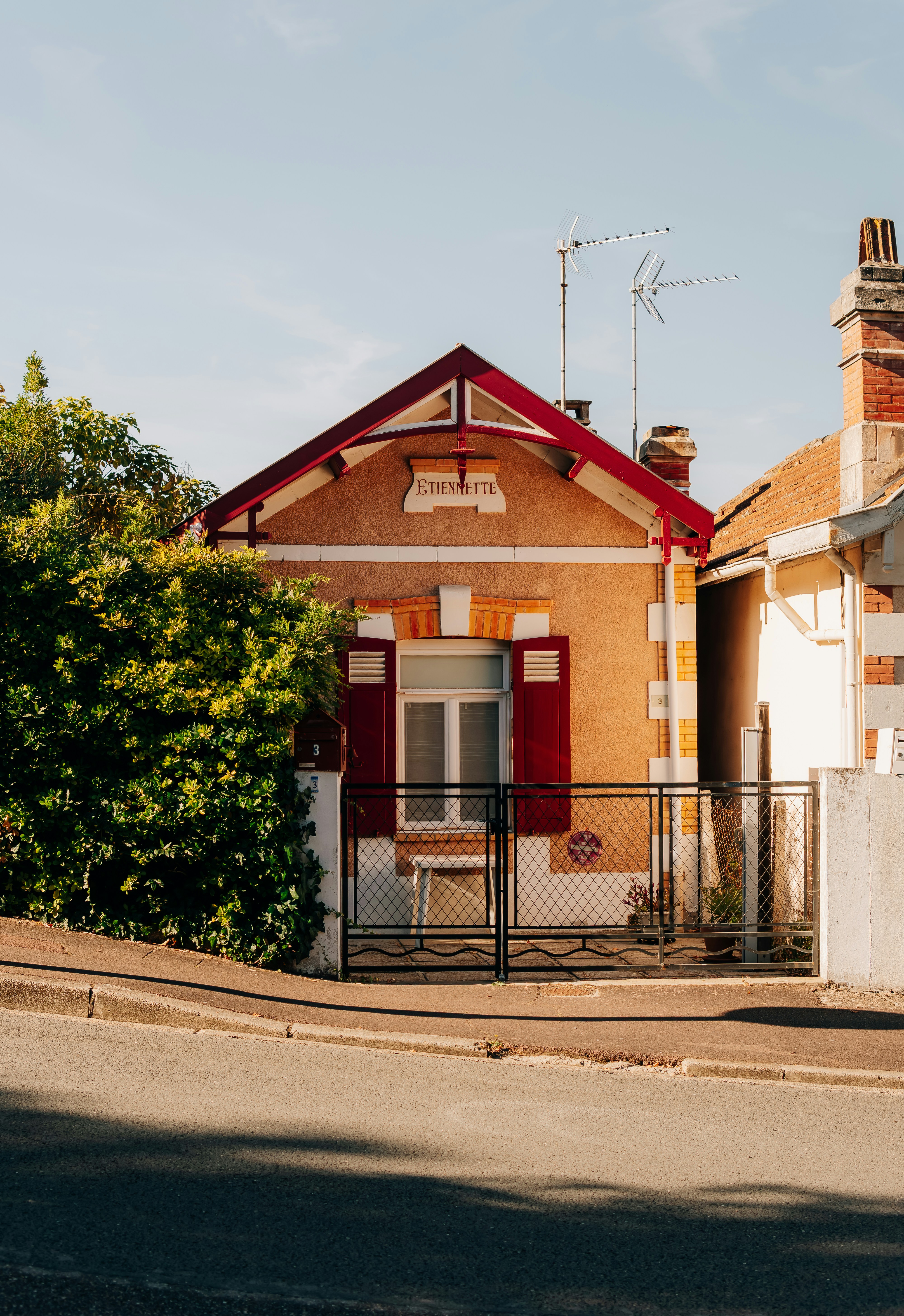 Front Facade of a Sunny Suburban House with Red Trim