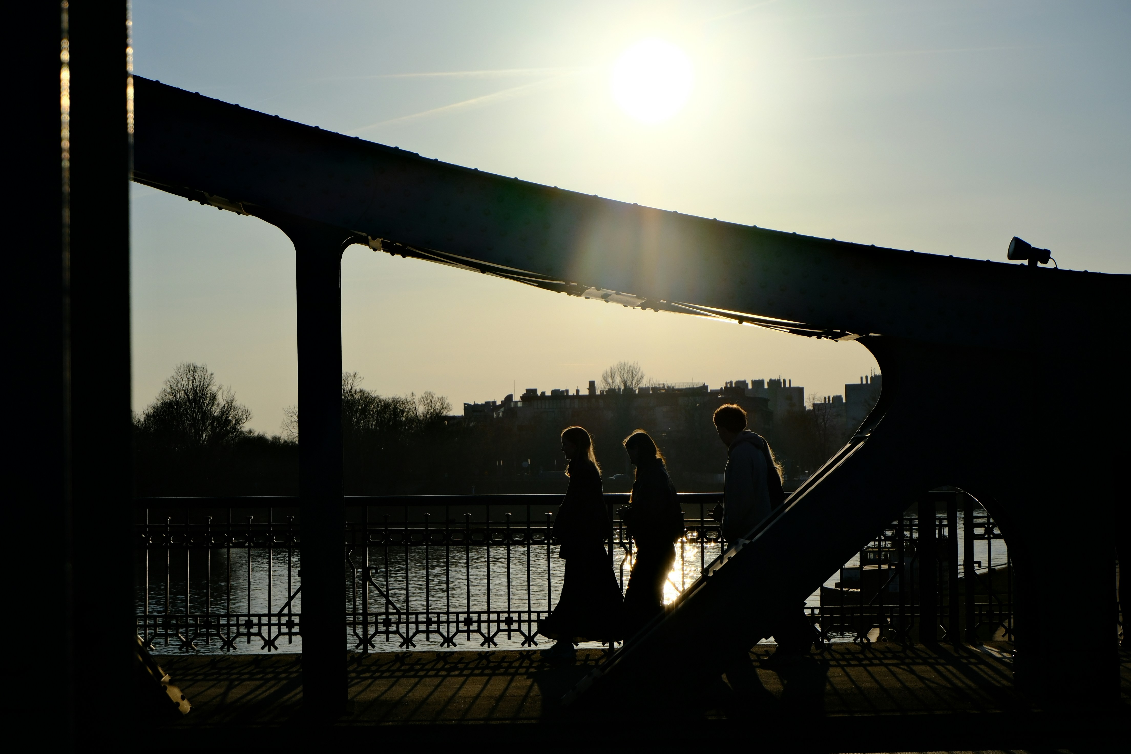 Sunlit Silhouettes on the Riverside Bridge