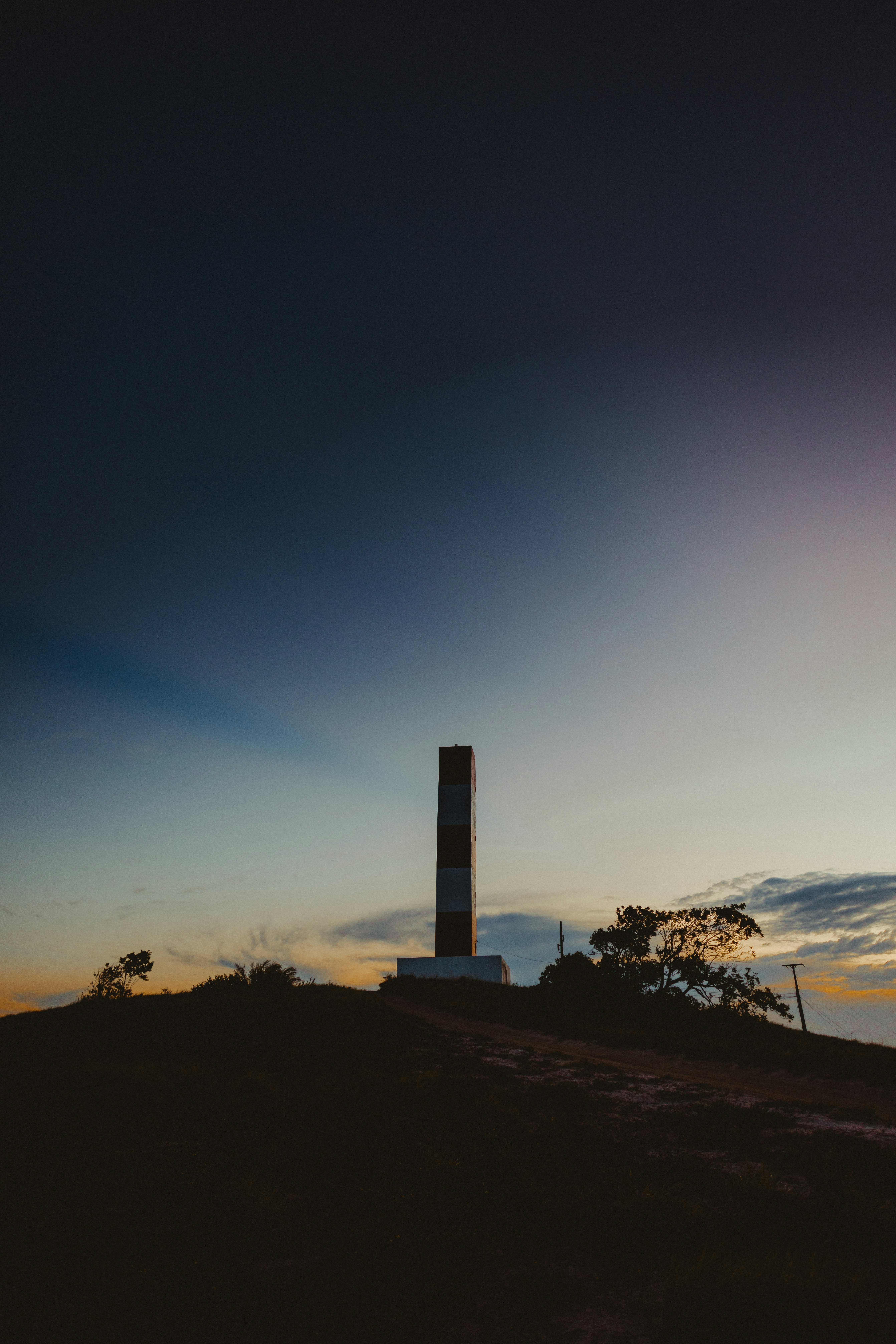 Tapered beacon on a darkened hill at dusk