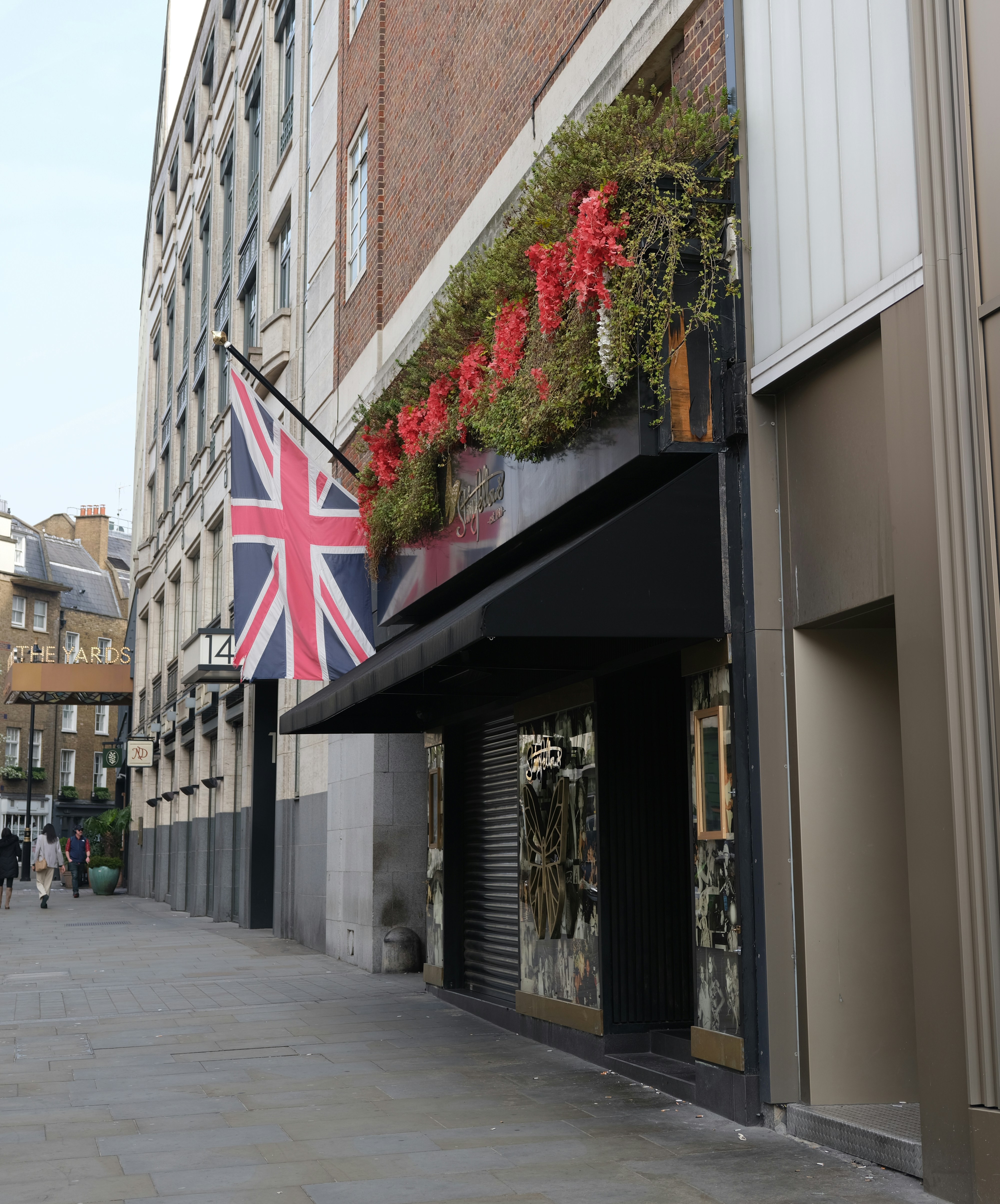 British Flag and Floral Arcade: A Street-Level Portrait of a Corner Pub Façade