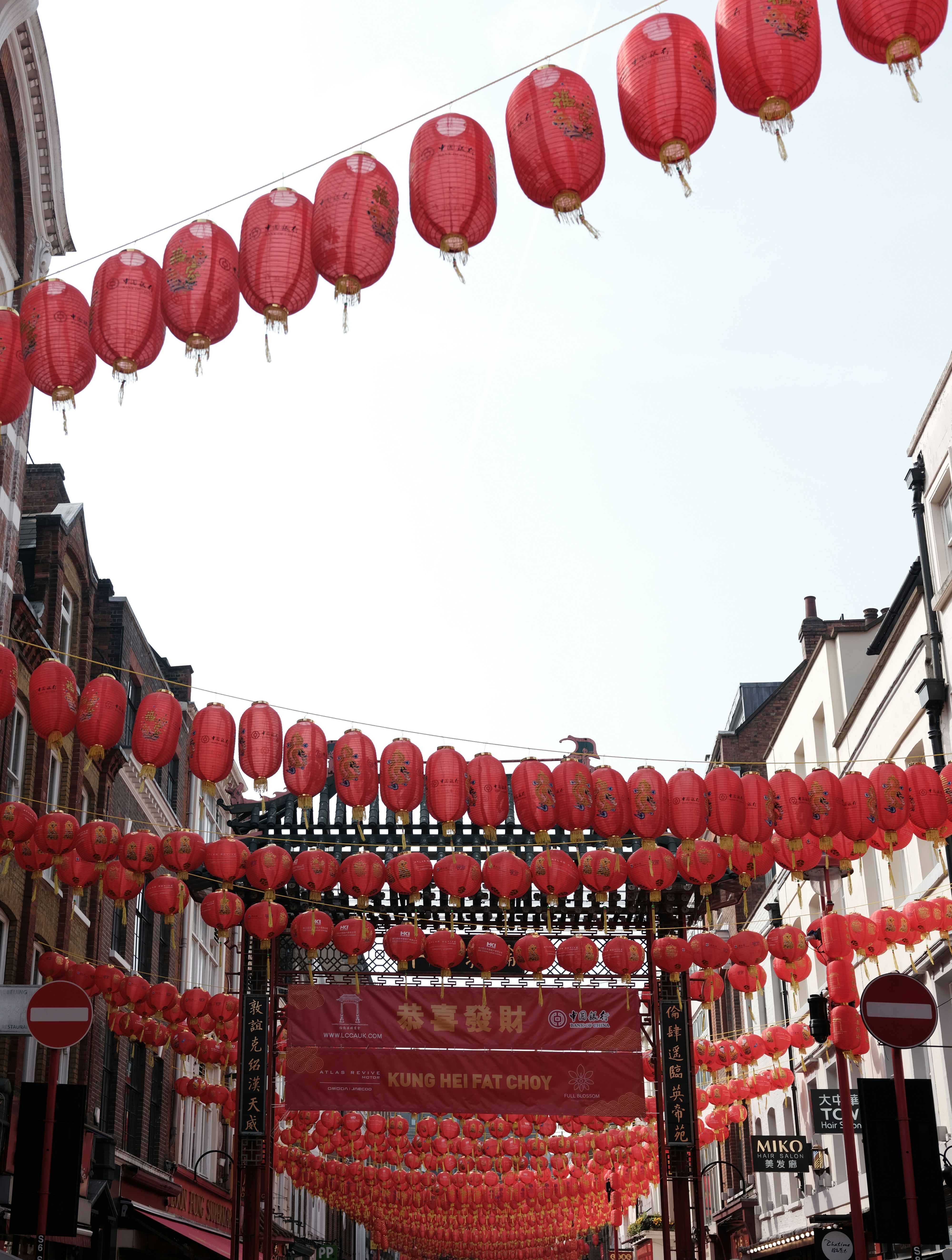 Lanterns over a vibrant street festival corridor