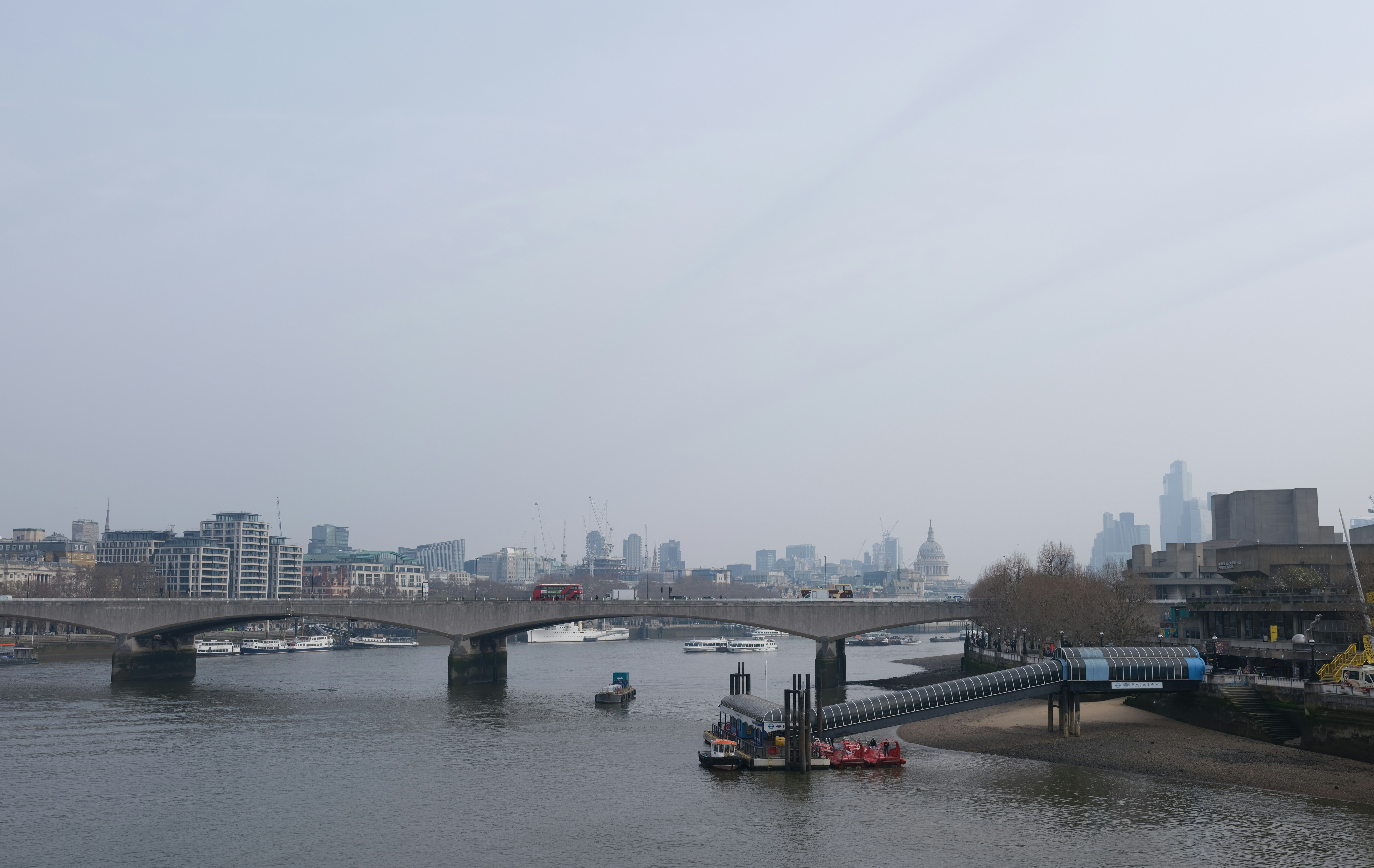 Cityscape Across the Thames: Bridges, Boats, and the Distant Skyline