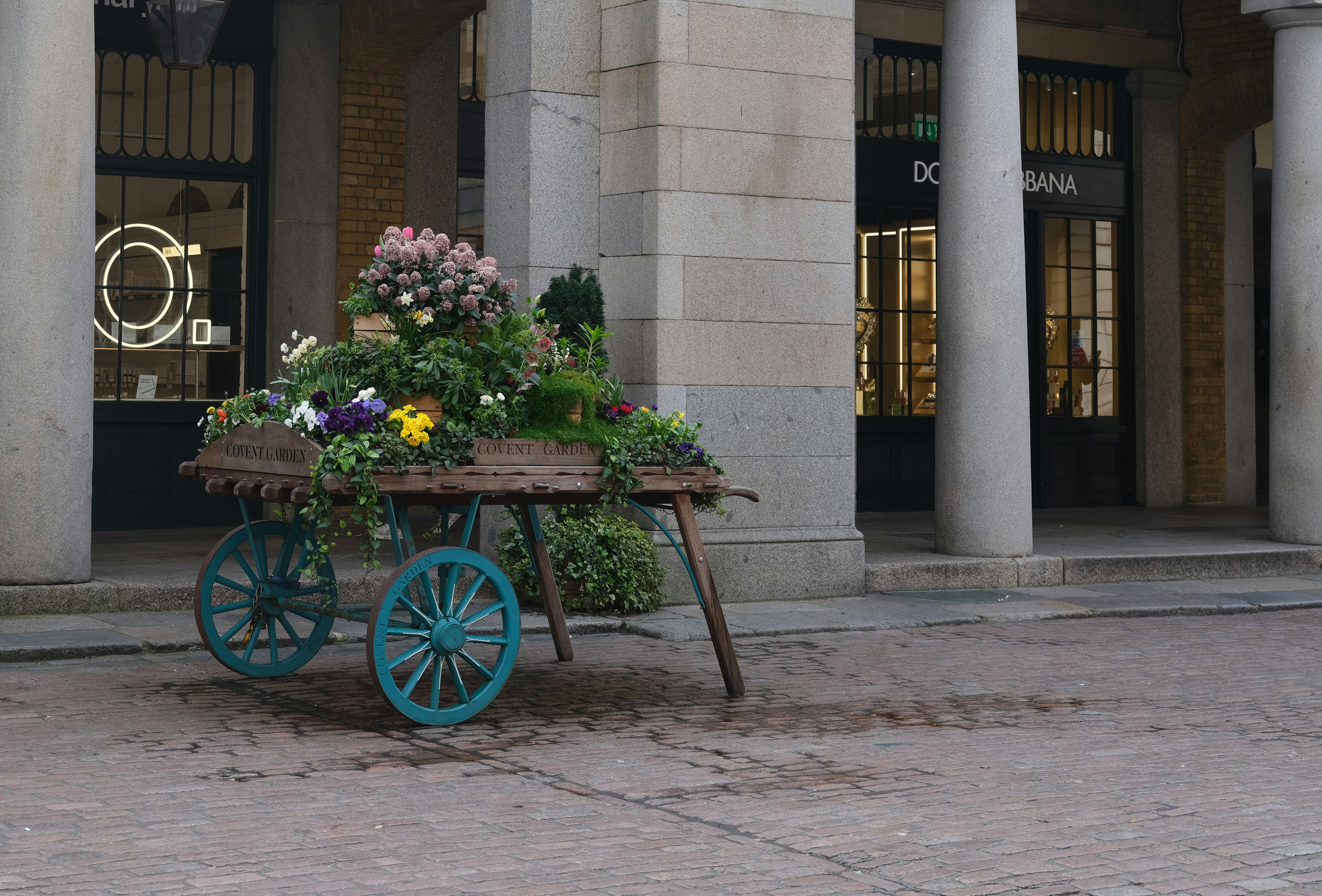 A Floraled Wagon Stand Beneath Stone Columns