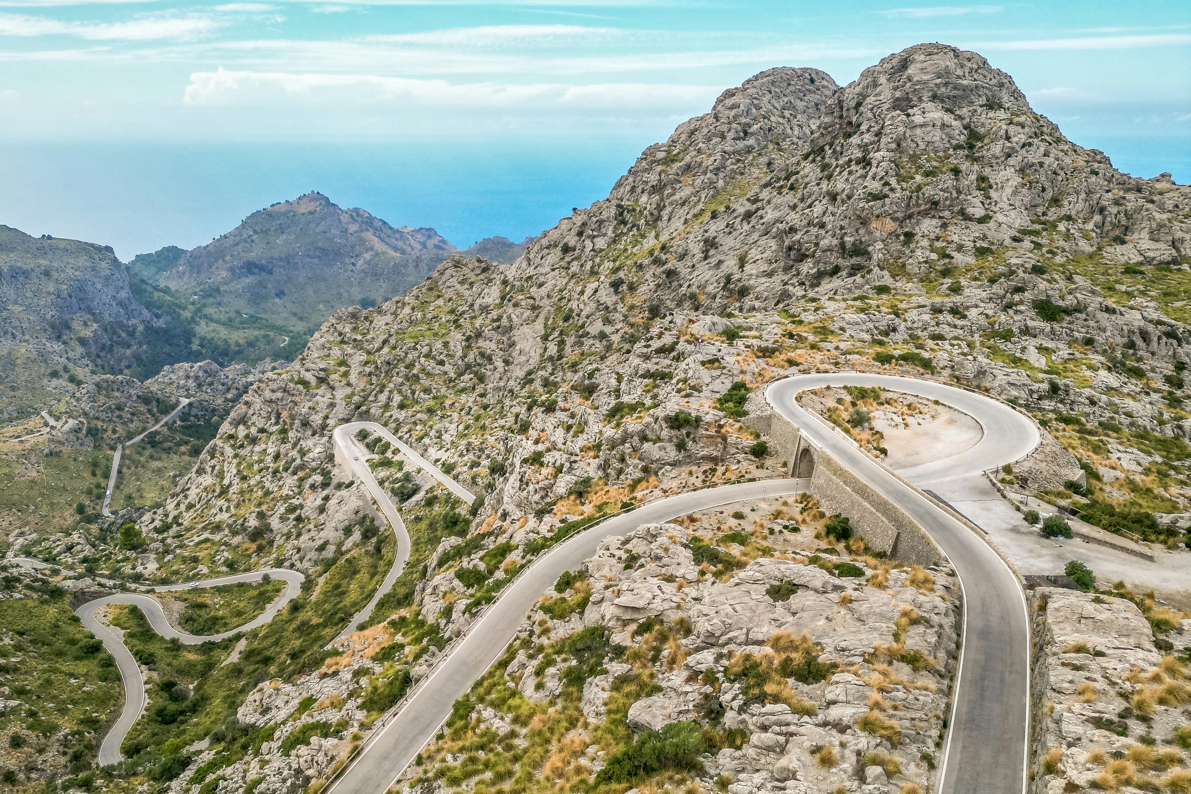 Winding Summit: A Serpentine Road Crowned by Rugged Peaks