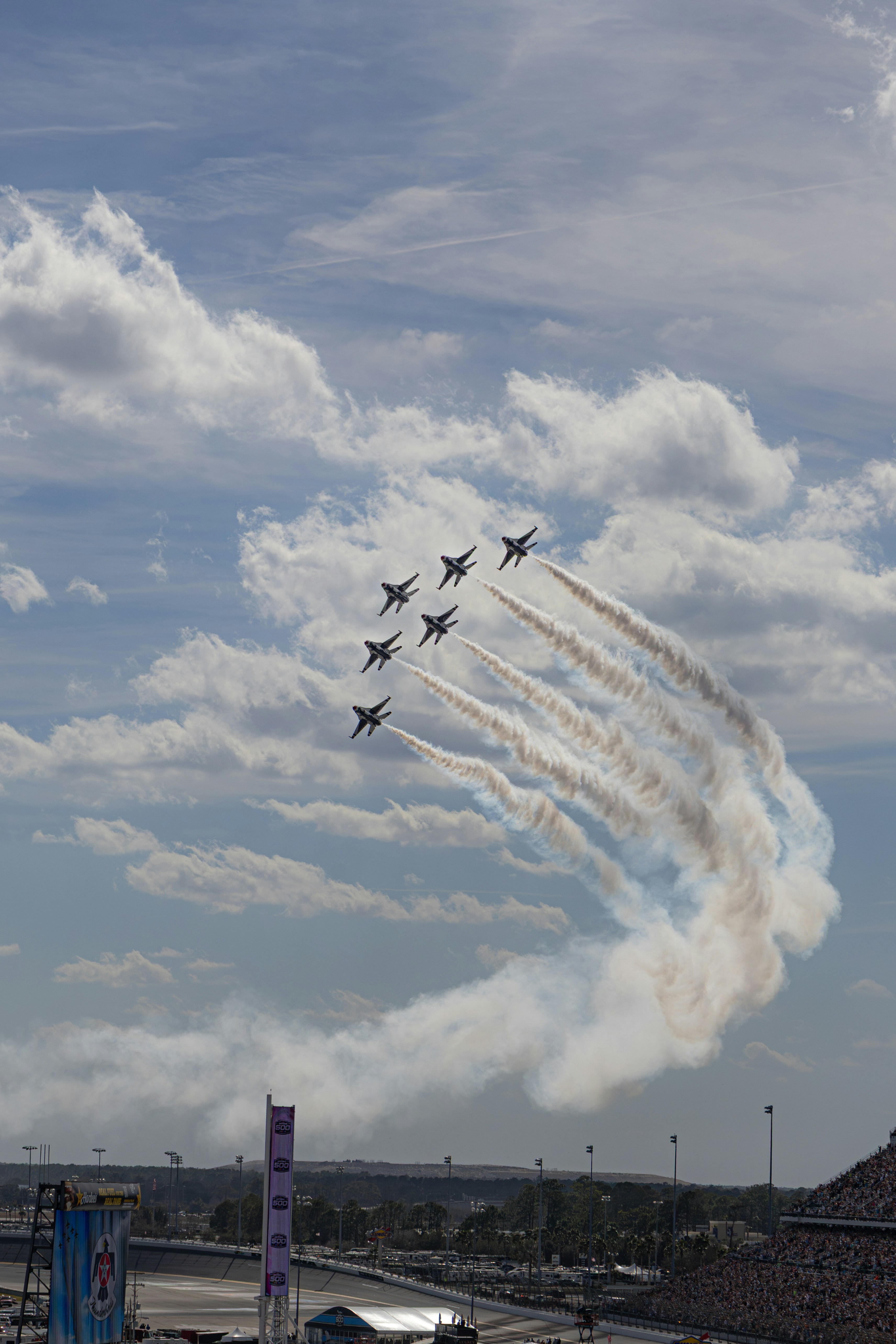 Six-jet aerial performance arcs across a bright sky