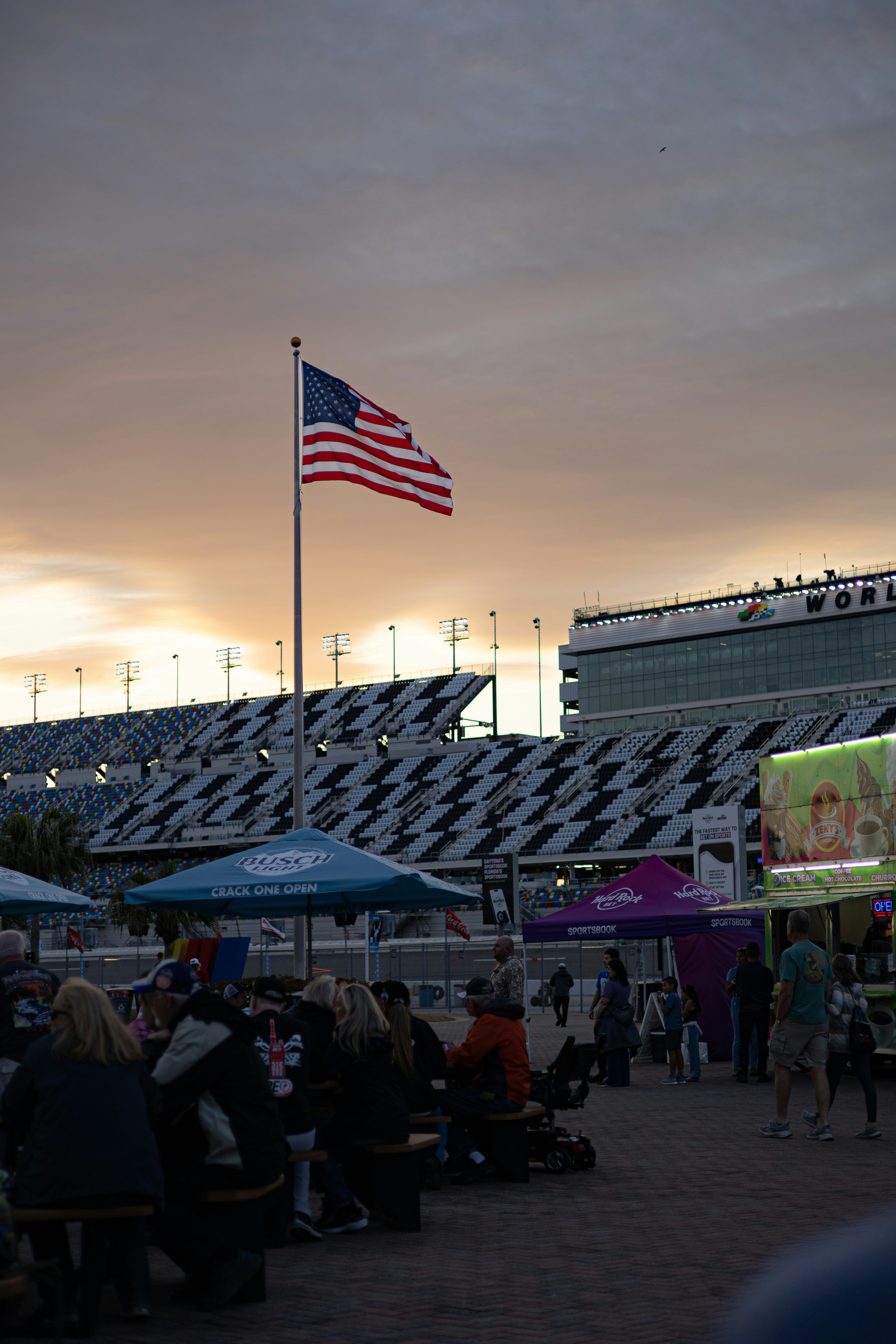Flag above the stadium at dusk, gathering under the sky