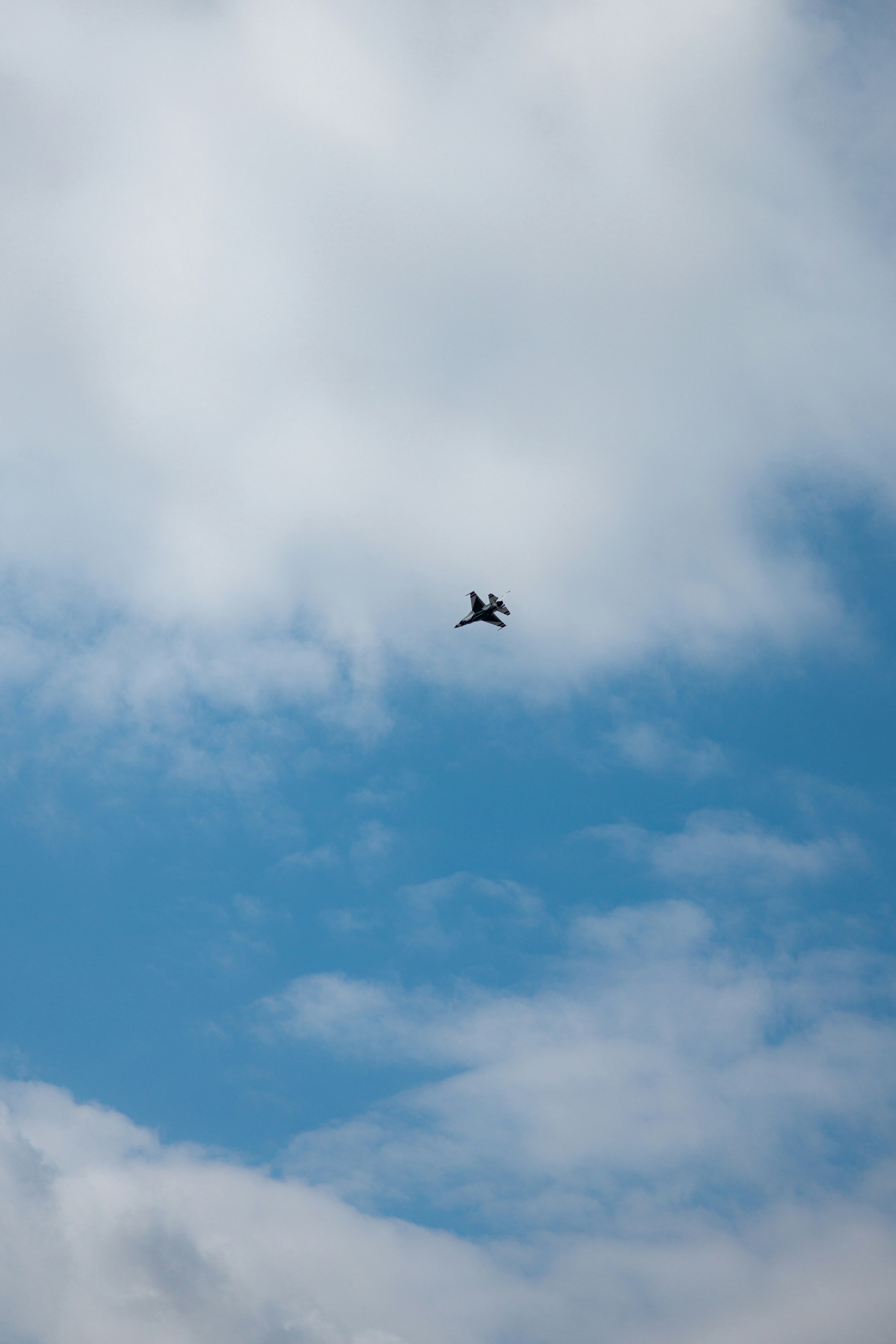 Soaring silhouette: a lone jet cuts through a cerulean sky