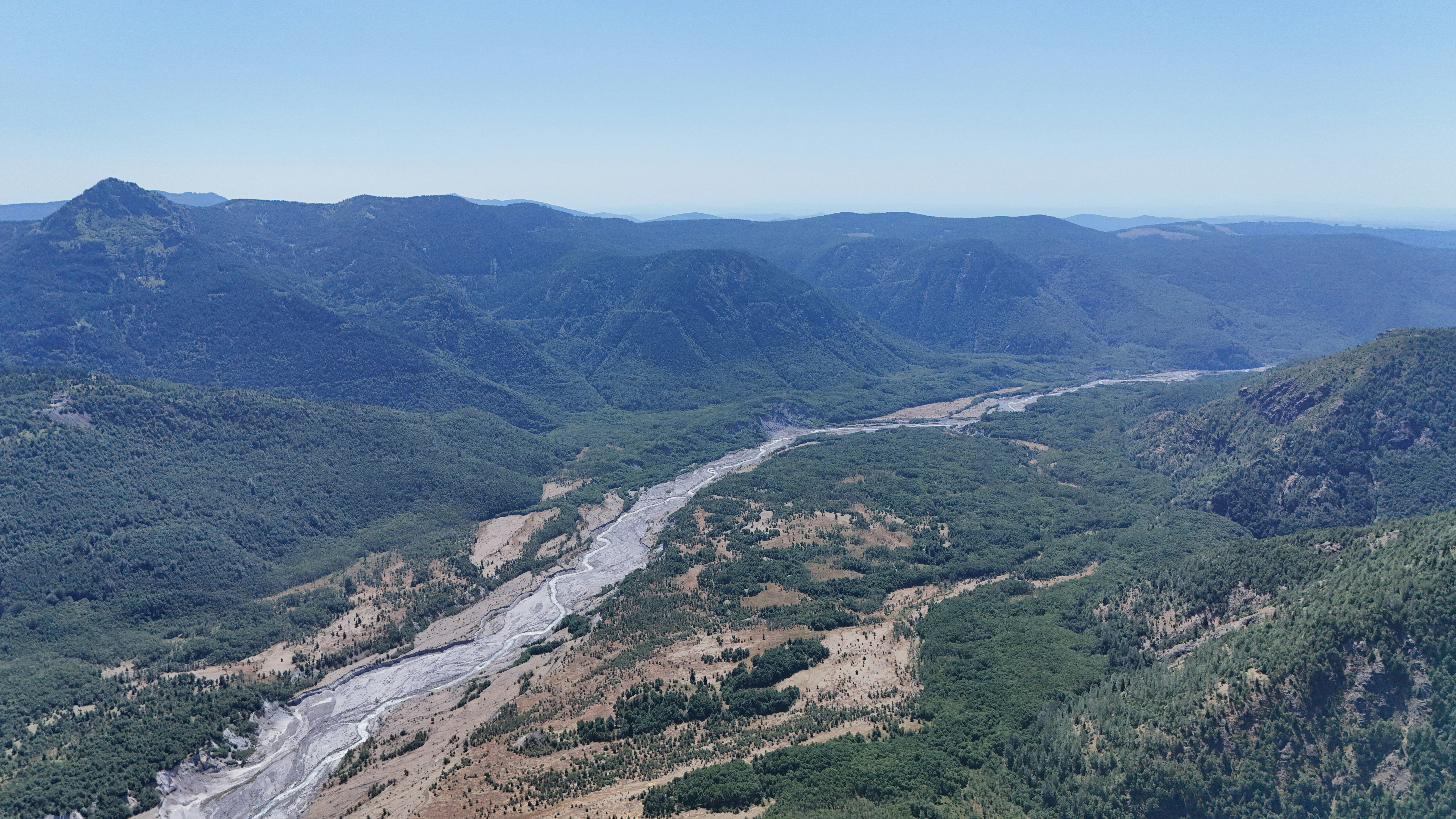 Ridge and River Bend: Aerial Crossing Through Mountain Basin