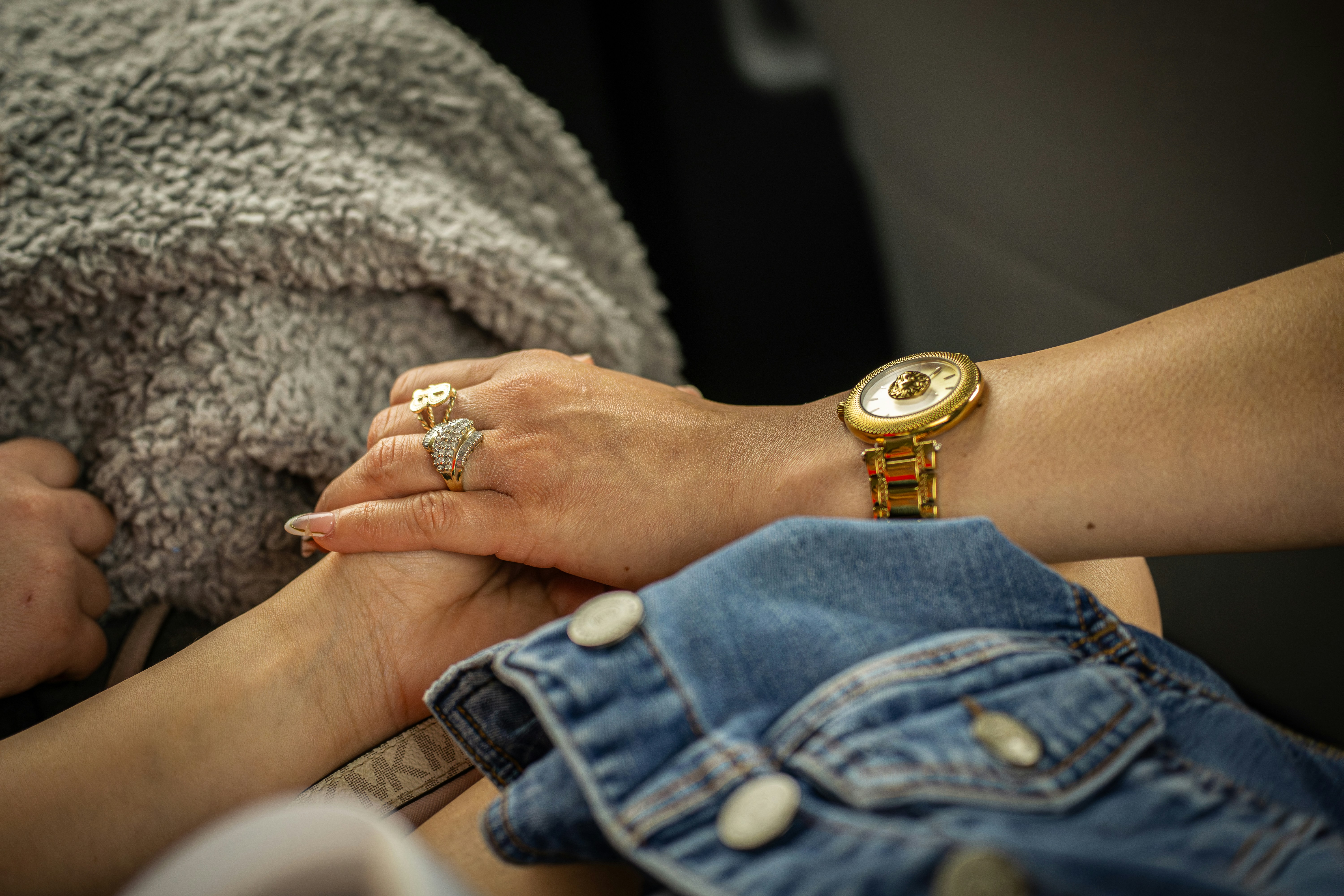 Hands in Quiet Connection: A Golden Watch and Denim Moment