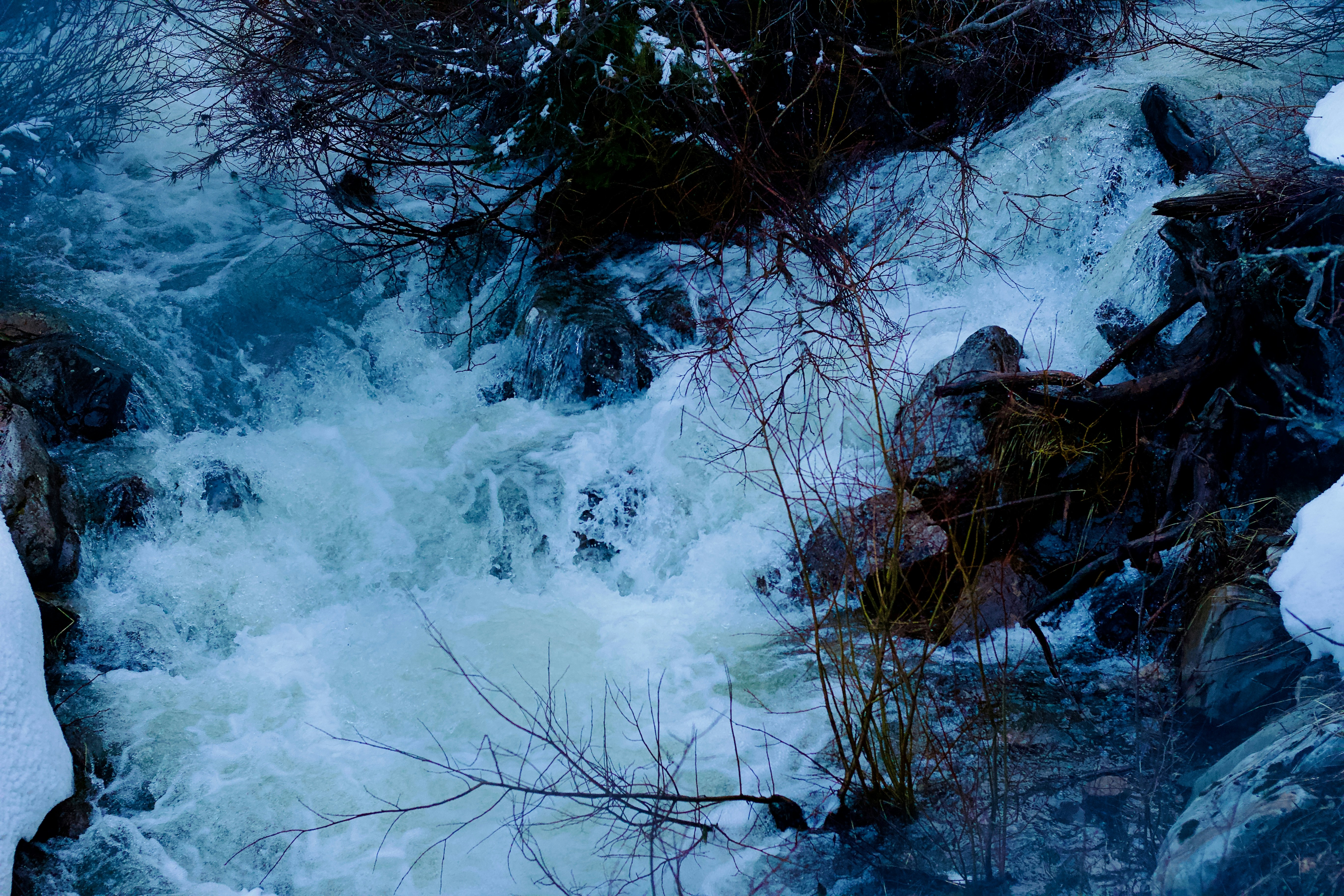 Rushing turquoise waters between jagged winter rocks