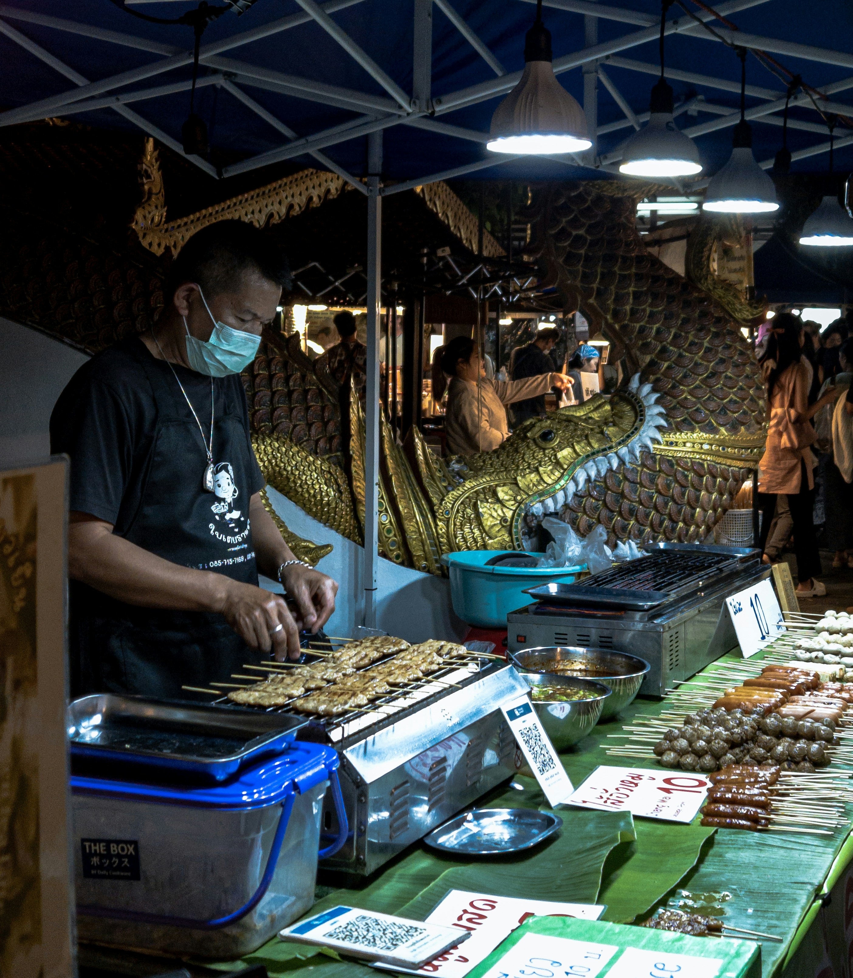 Under the Market Lights: Skewers, Shadows, and a Dragon Backdrop
