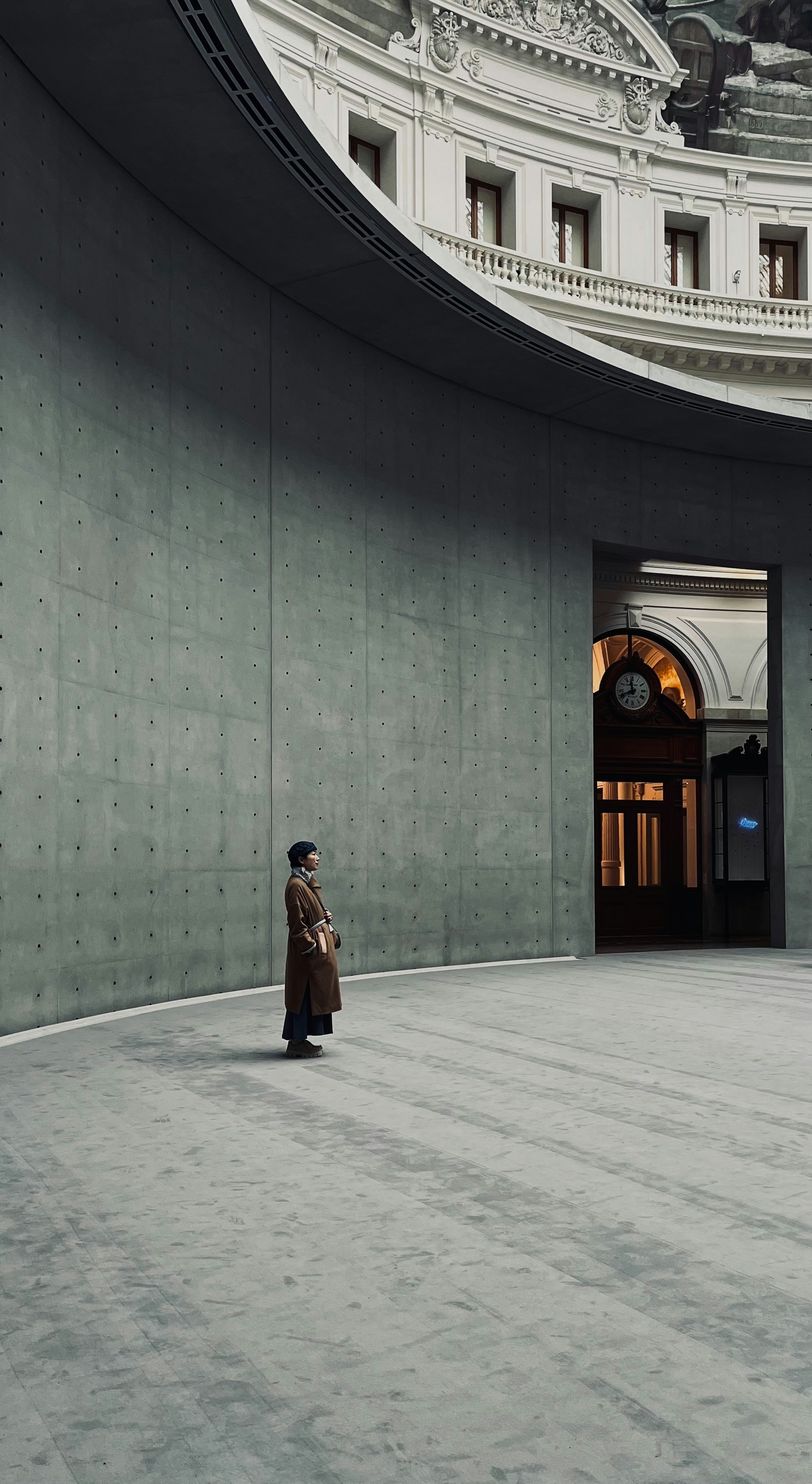  solitary figure beneath a curved gallery