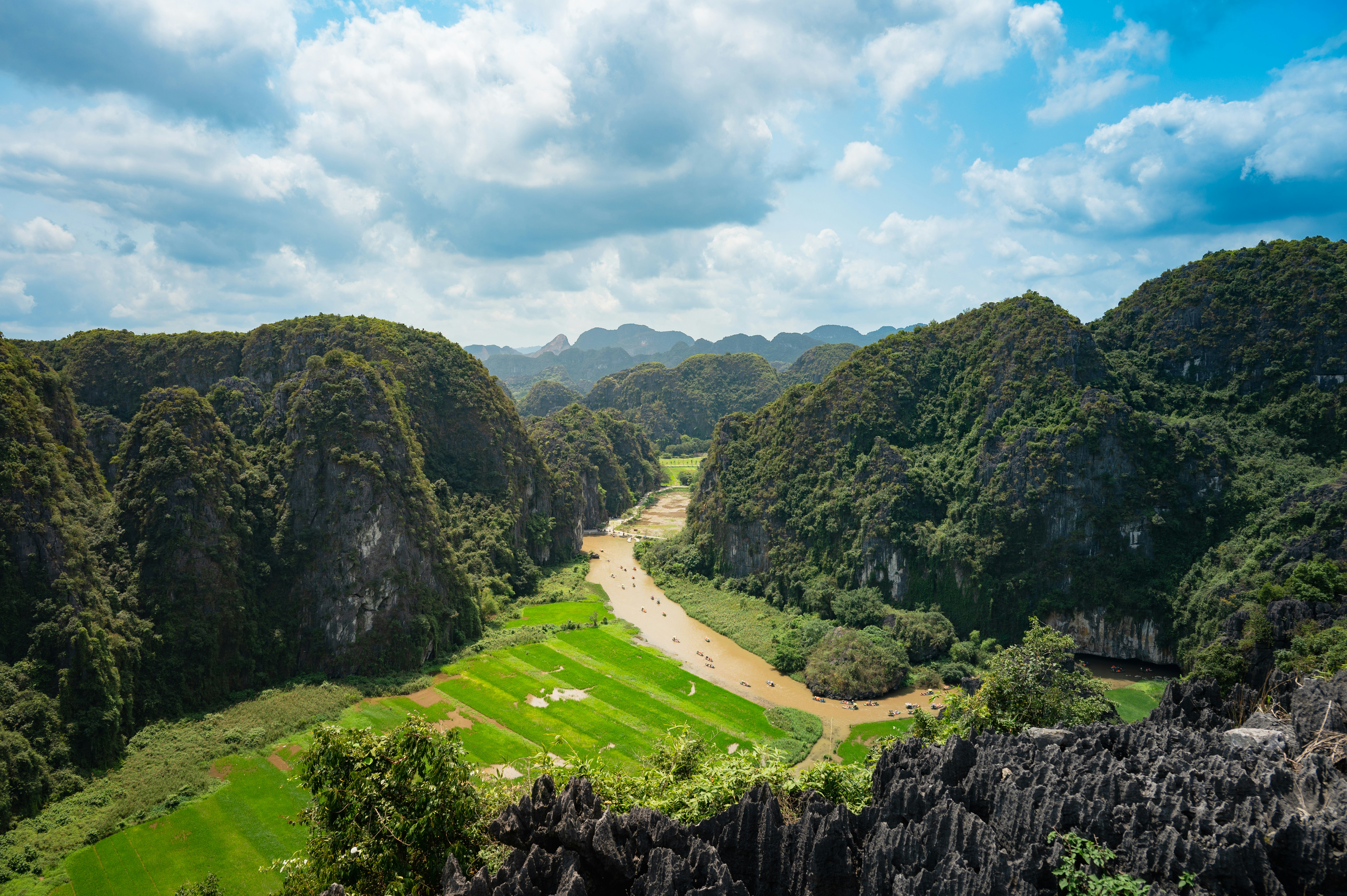 Valley of Limestone Pillars and Green Terraces Under a Bright Sky
