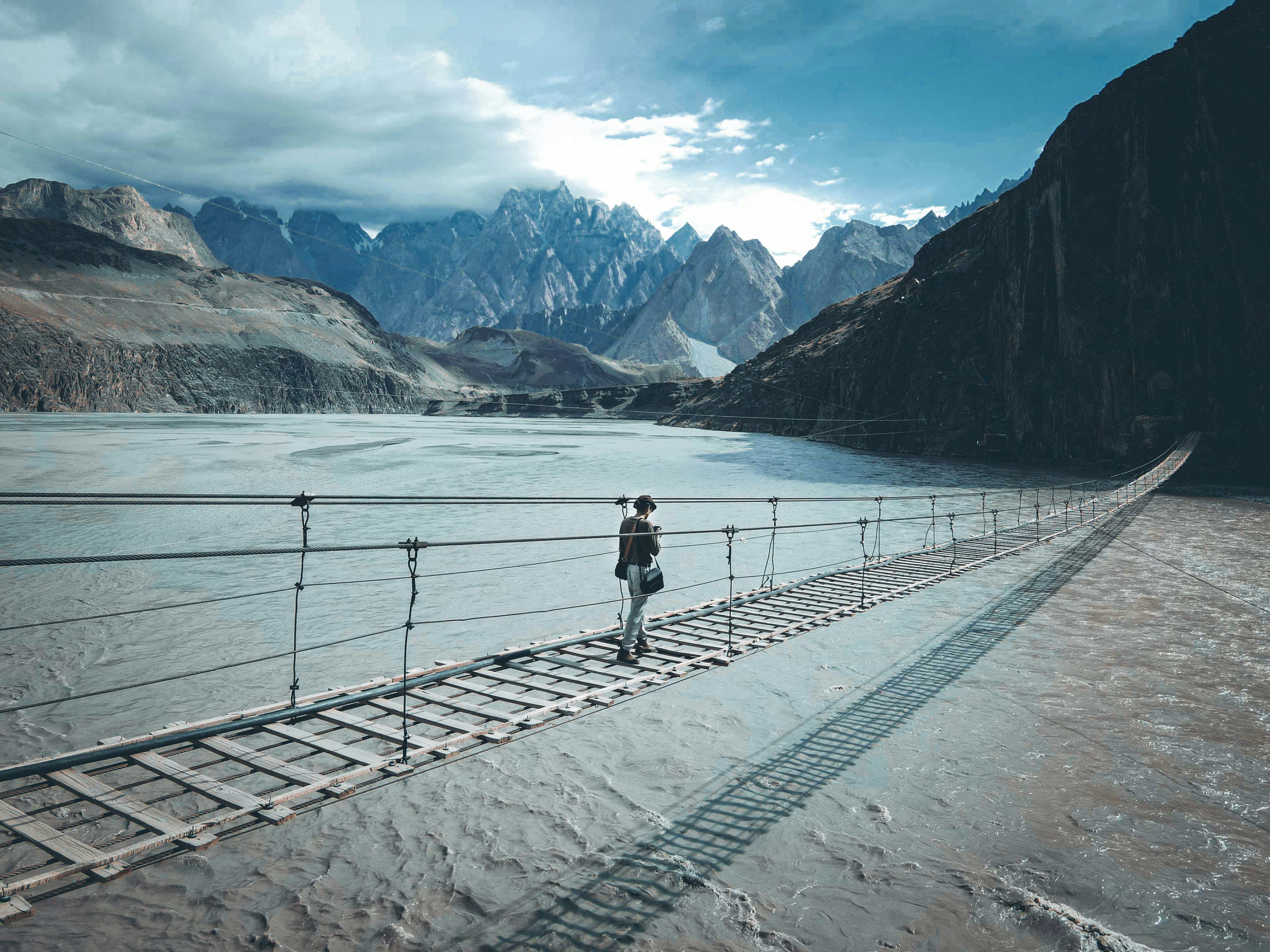 Footsteps on a Suspended Toll Bridge Beneath Alpine Peaks
