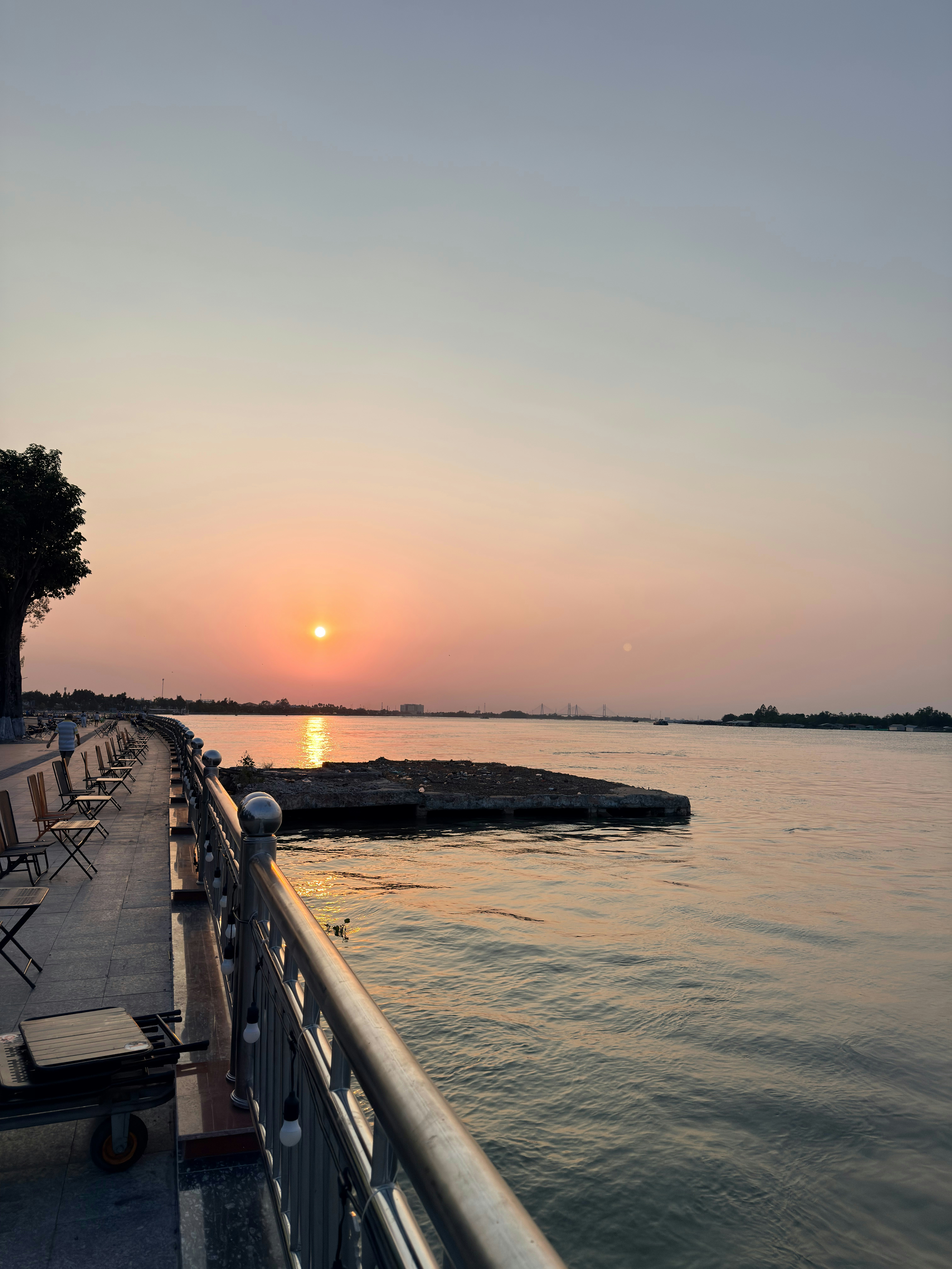 Sunset along the waterfront promenade with ferris-silver railing