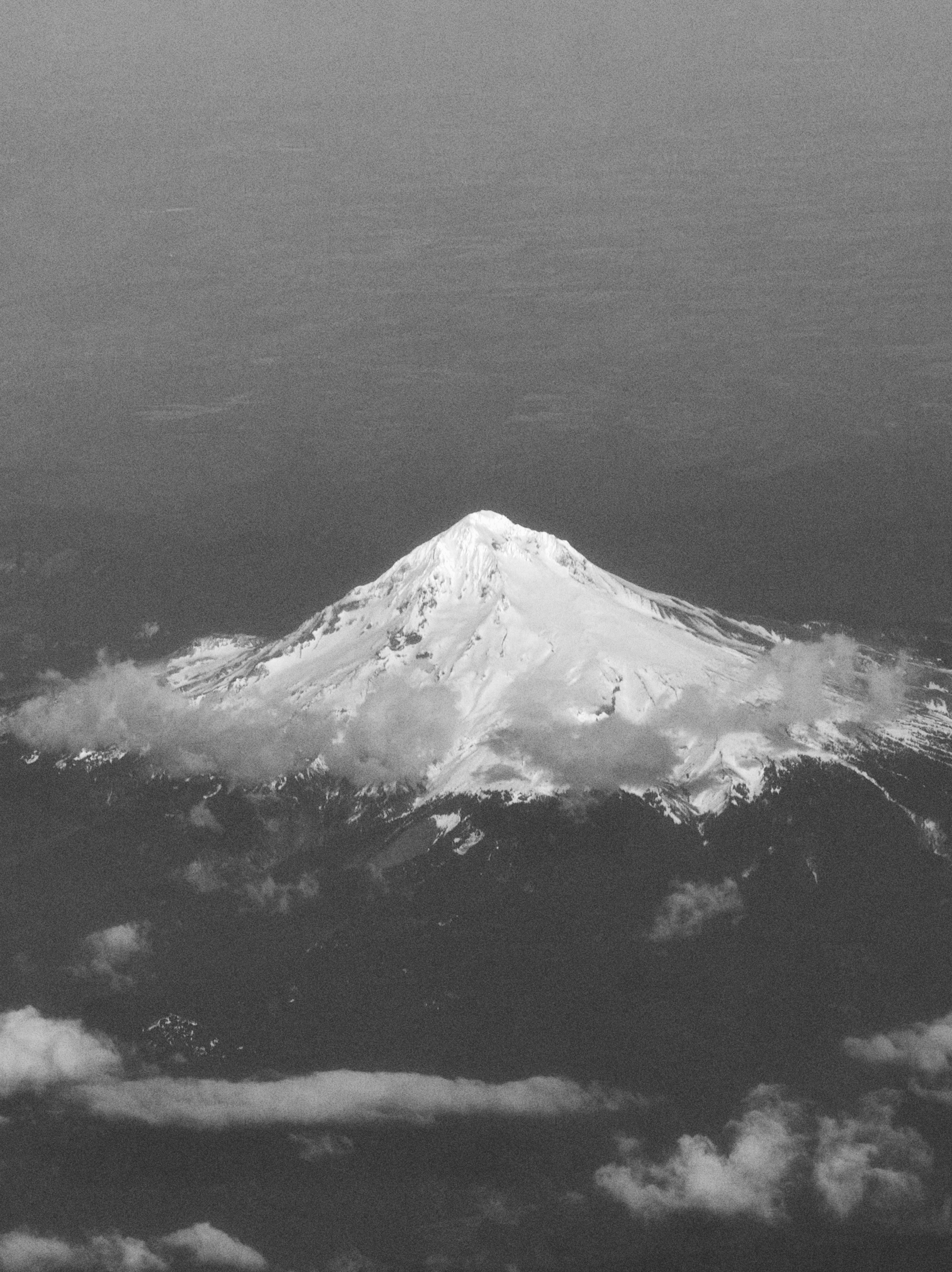 Summit in Silence: A Snow-Capped Peak Piercing the Clouds