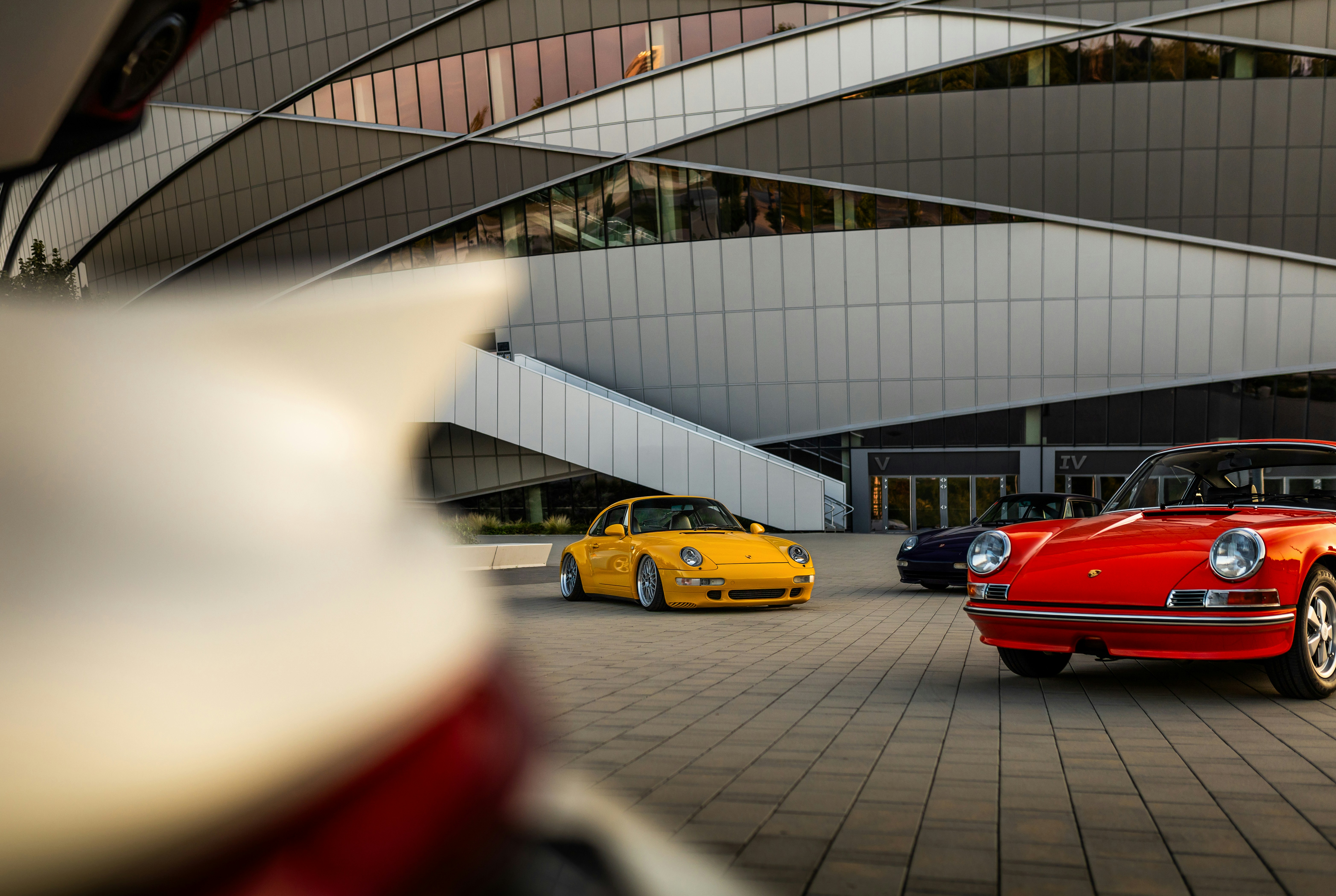 Classic Car Courtyard: A Citrus Yellow和Crimson Red in Front of Futuristic Facade
